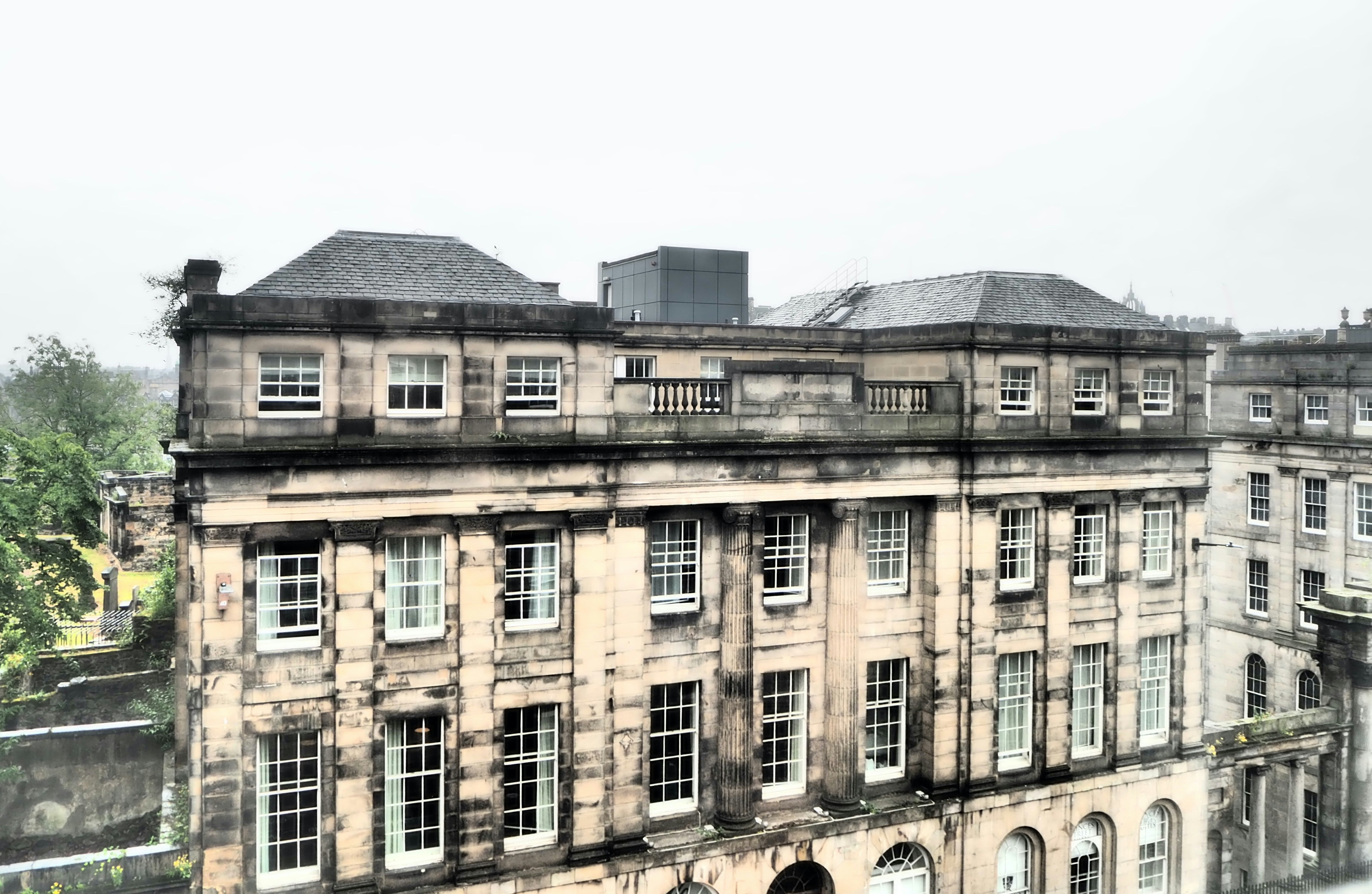 Elegant stone buildings with classical architecture on a misty day.