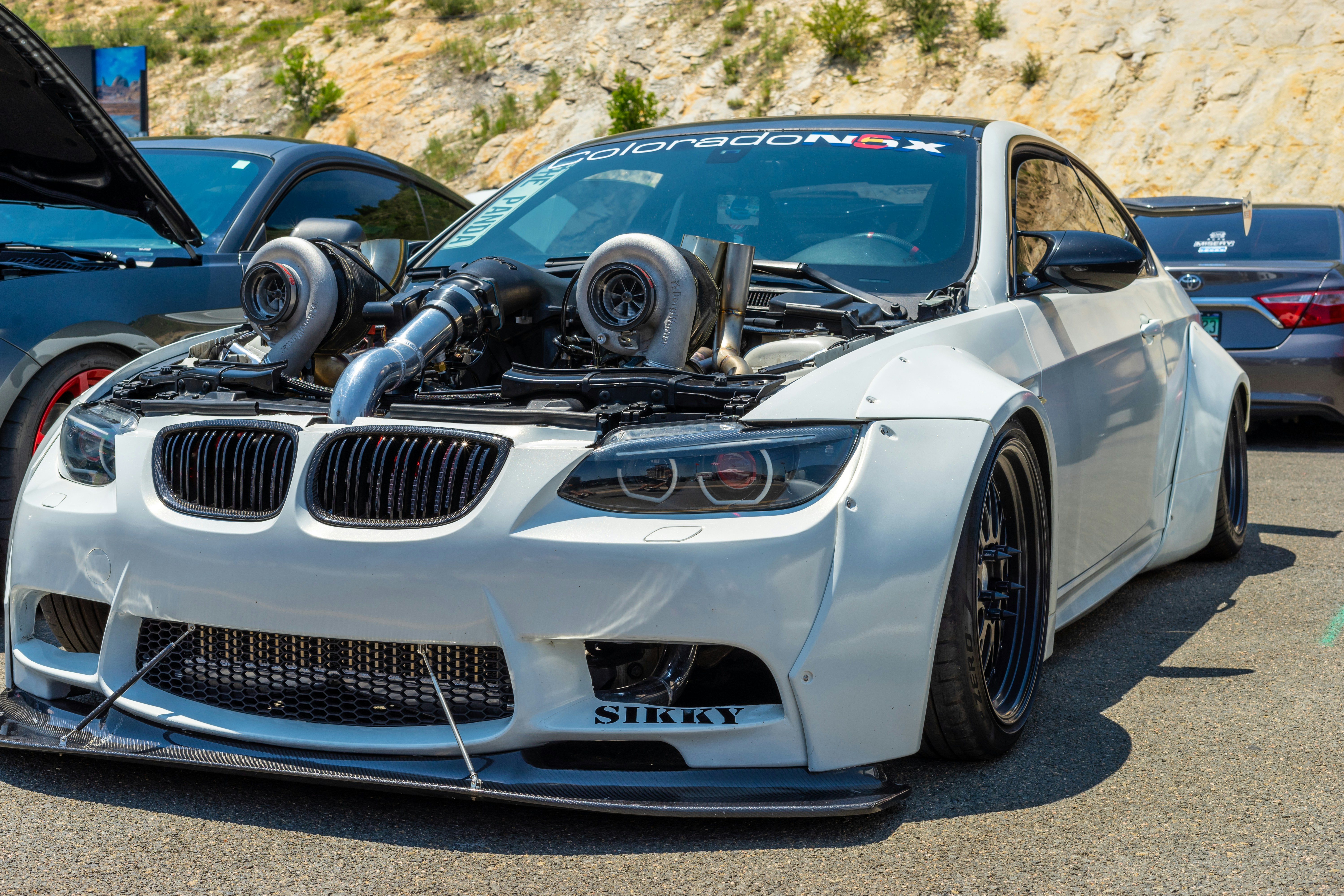 Turbocharged Stance: A White BMW With Dual Turbo Drones at a Car Meet