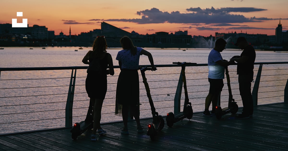 Silueta De 2 Mujeres De Pie En El Muelle Durante La Puesta Del Sol Foto
