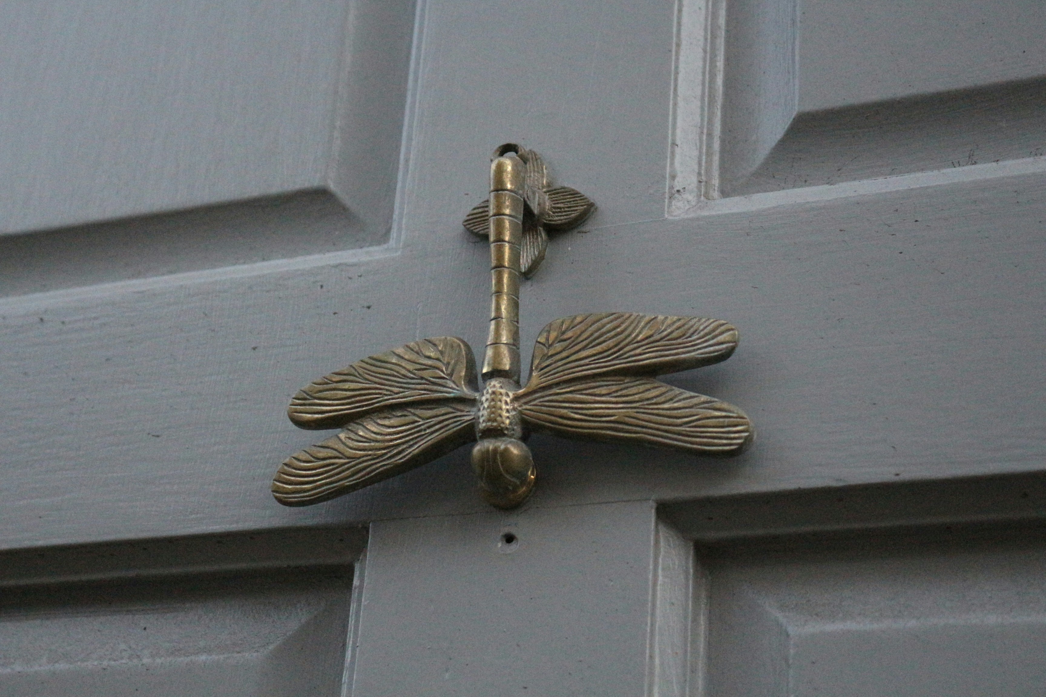 gold angel figurine on white wooden door