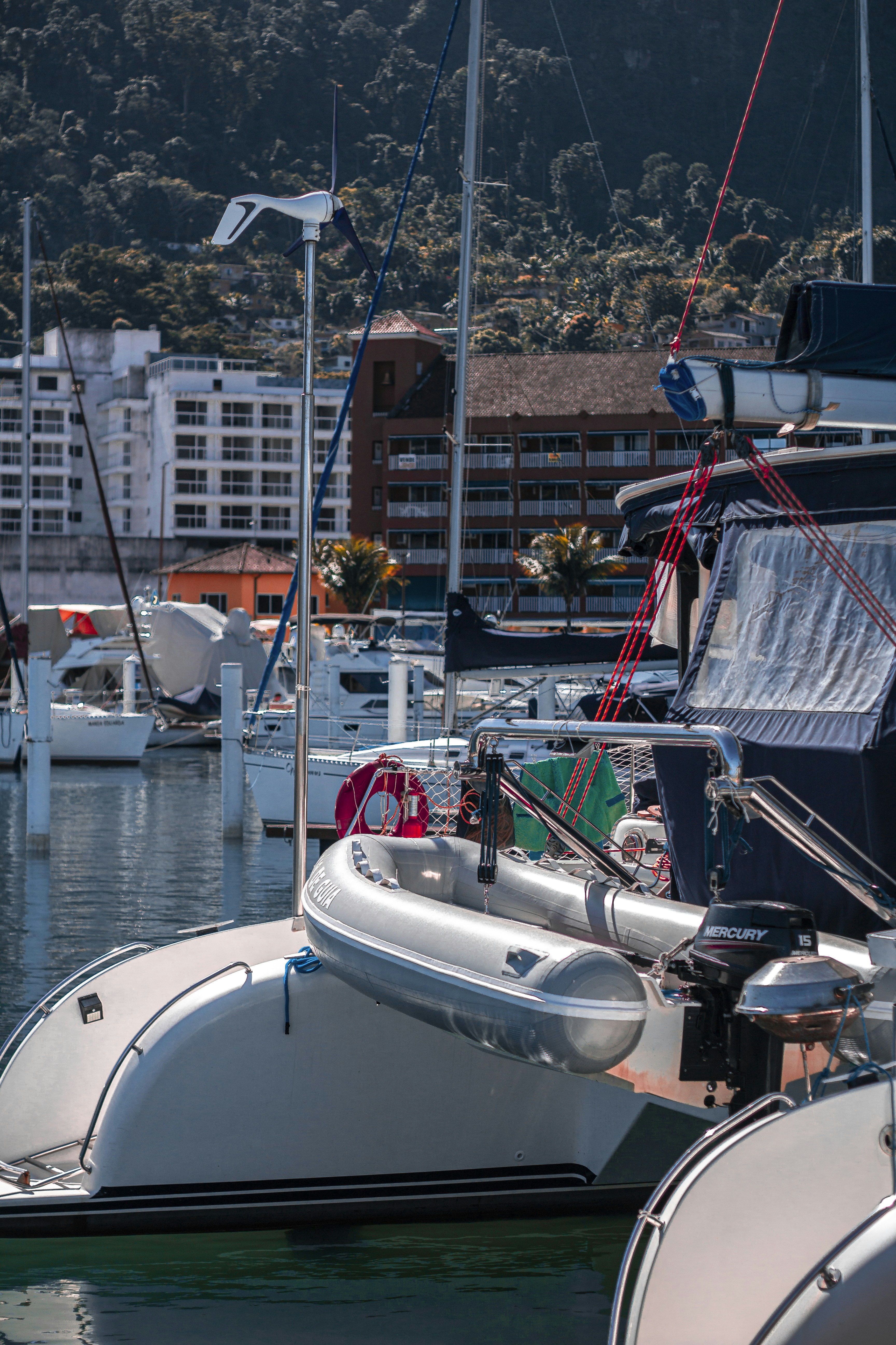 Docked boats under clear skies with lush hills in the background.