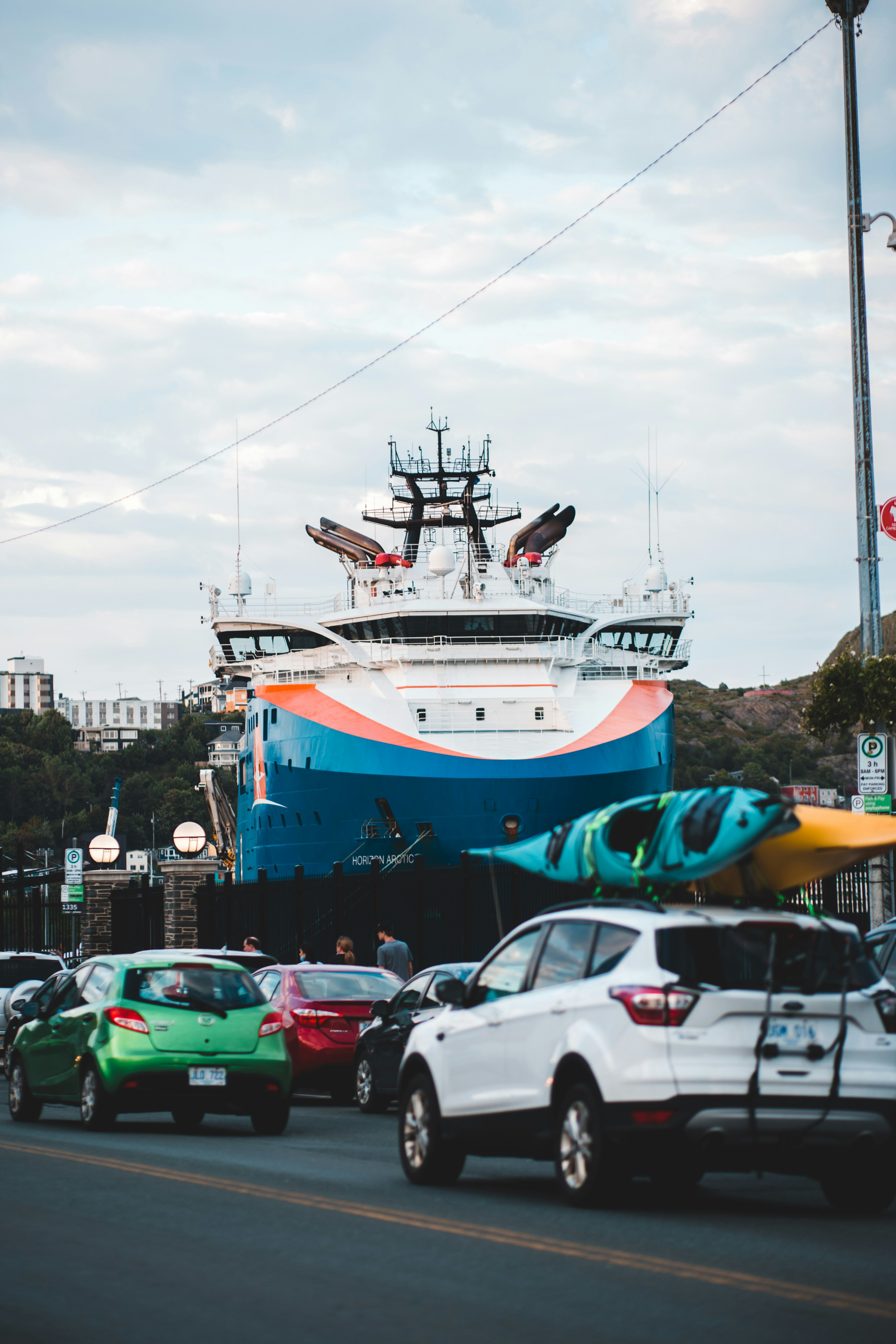 Harbor Colossus: The Blue-and-Orange Cruise Ship Framed by Urban Traffic