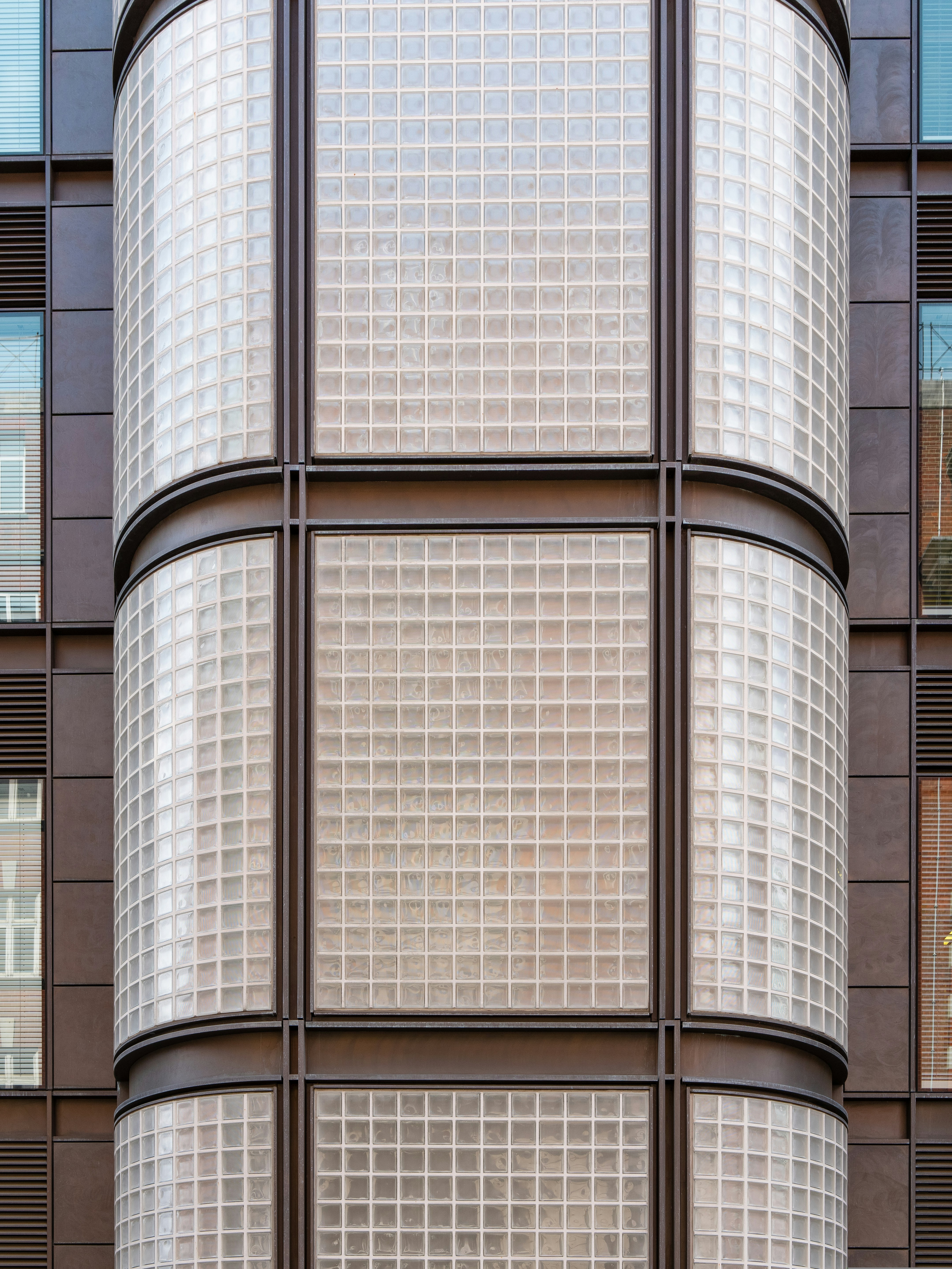 Curved glass block facade with metal framing on a modern building.