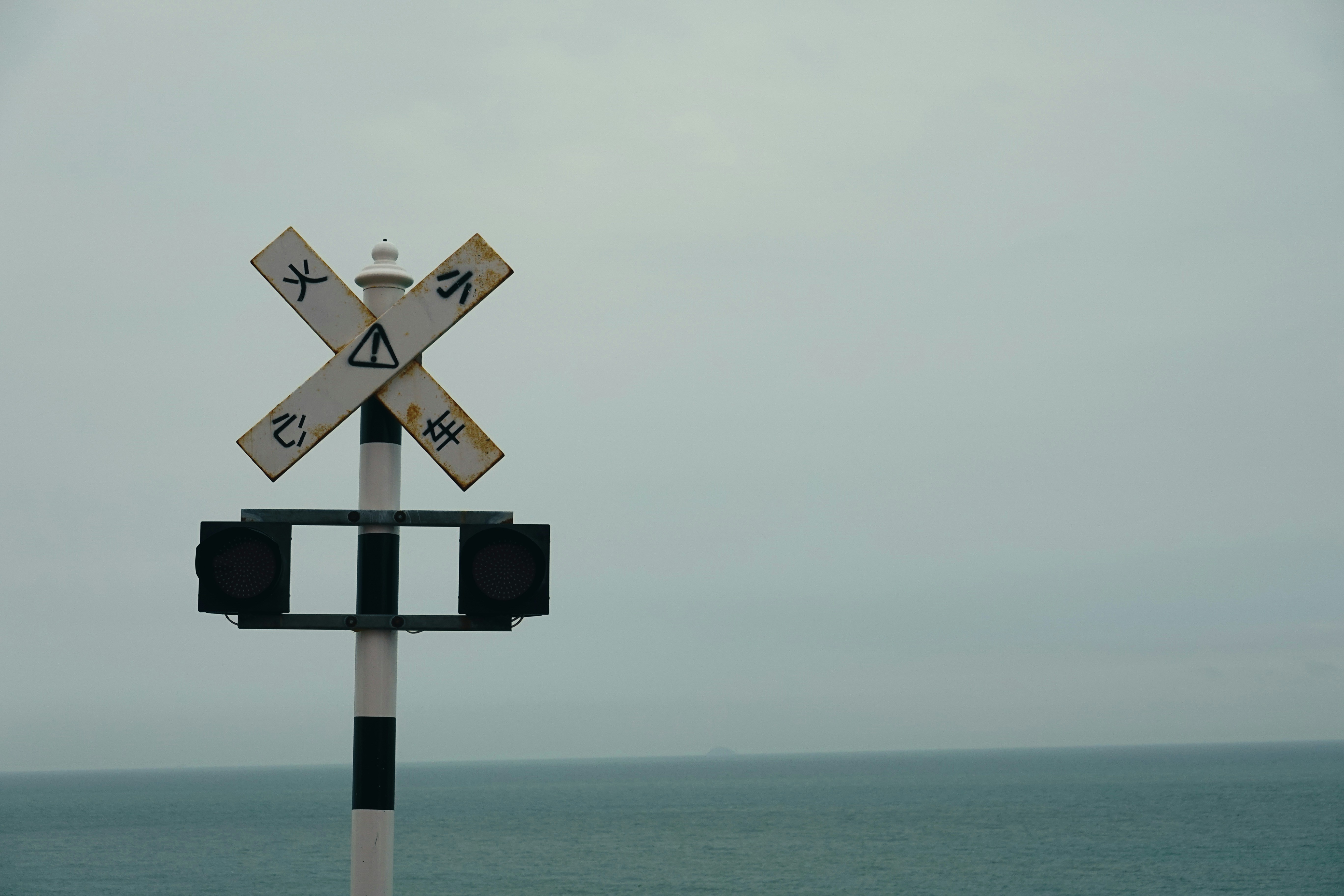 Lone Crossbuck by the Ocean: A Quiet Signal on the Horizon