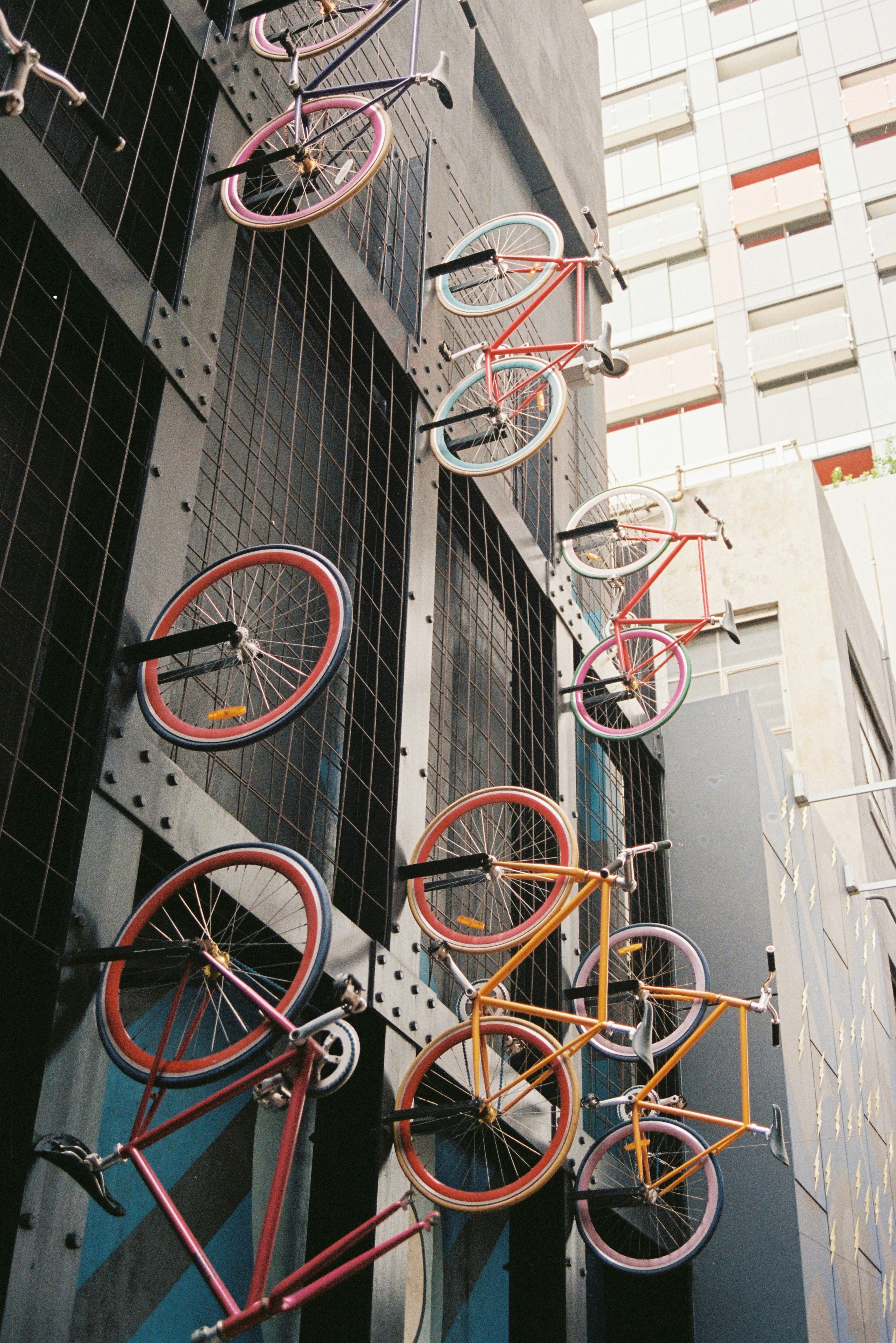 Vertical Bicycle Cascade: A Colorful Urban Sculpture on Glass and Steel