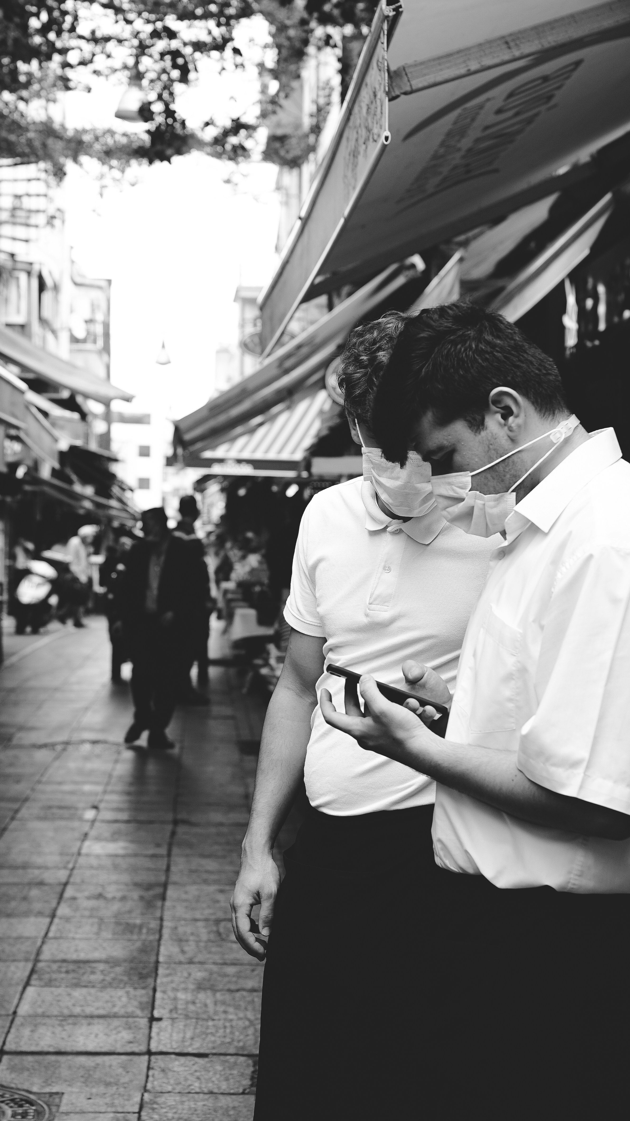 Masks and a Moment: A Quiet Phone Exchange on a Monochrome Street