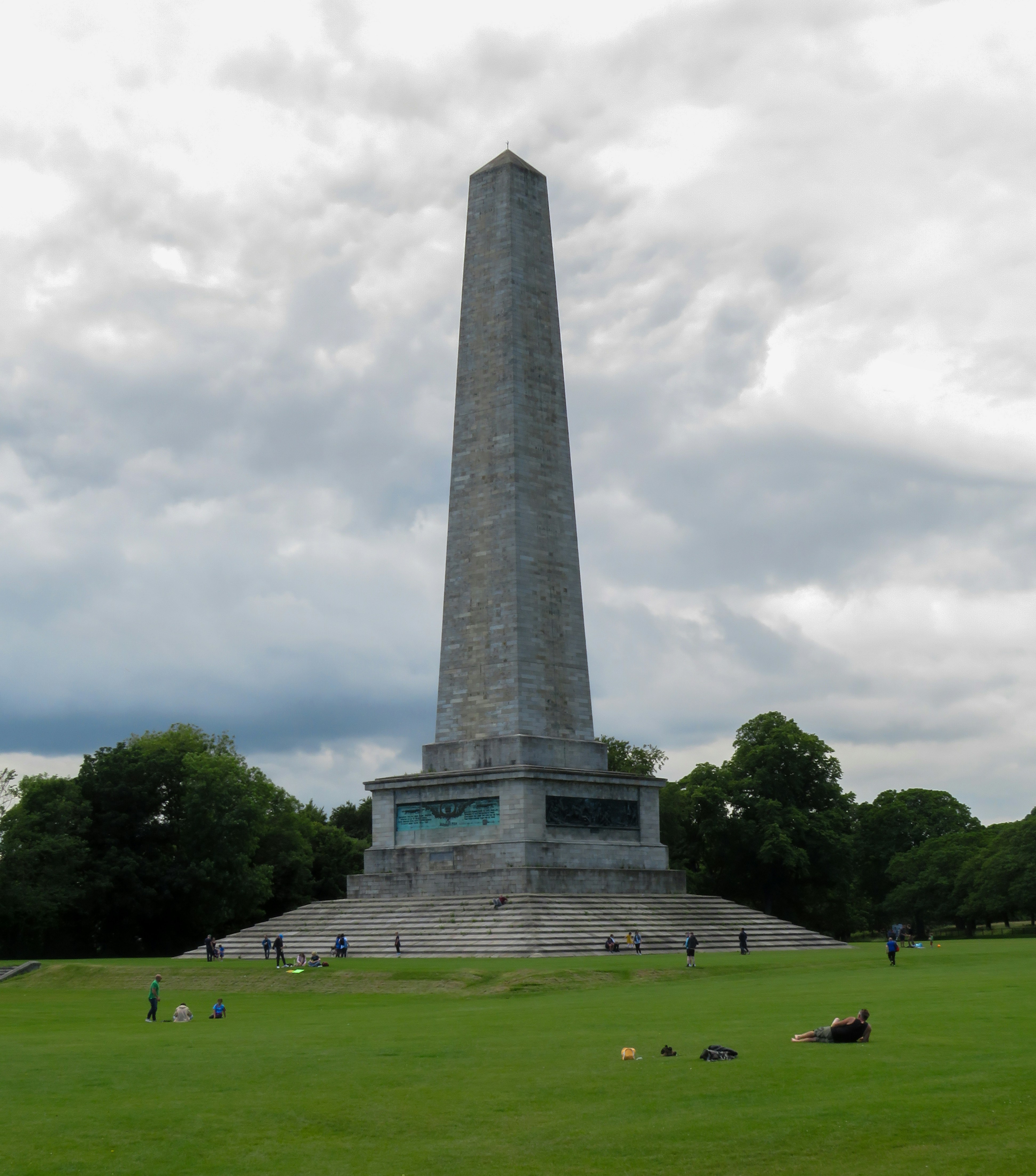 Gray concrete monument on green grass field under gray cloudy sky ...