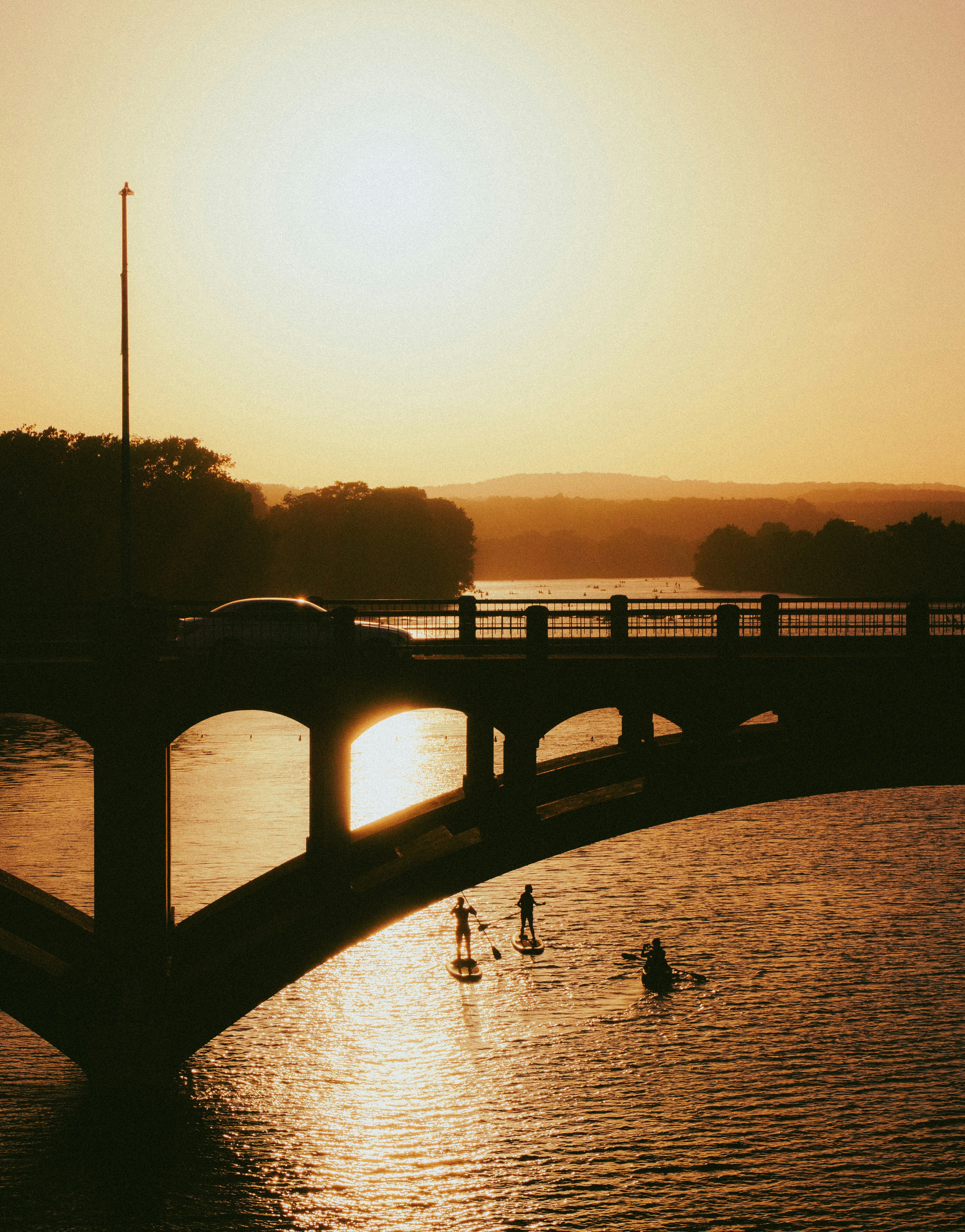 Sunlit Silhouette Over a Riverside Bridge