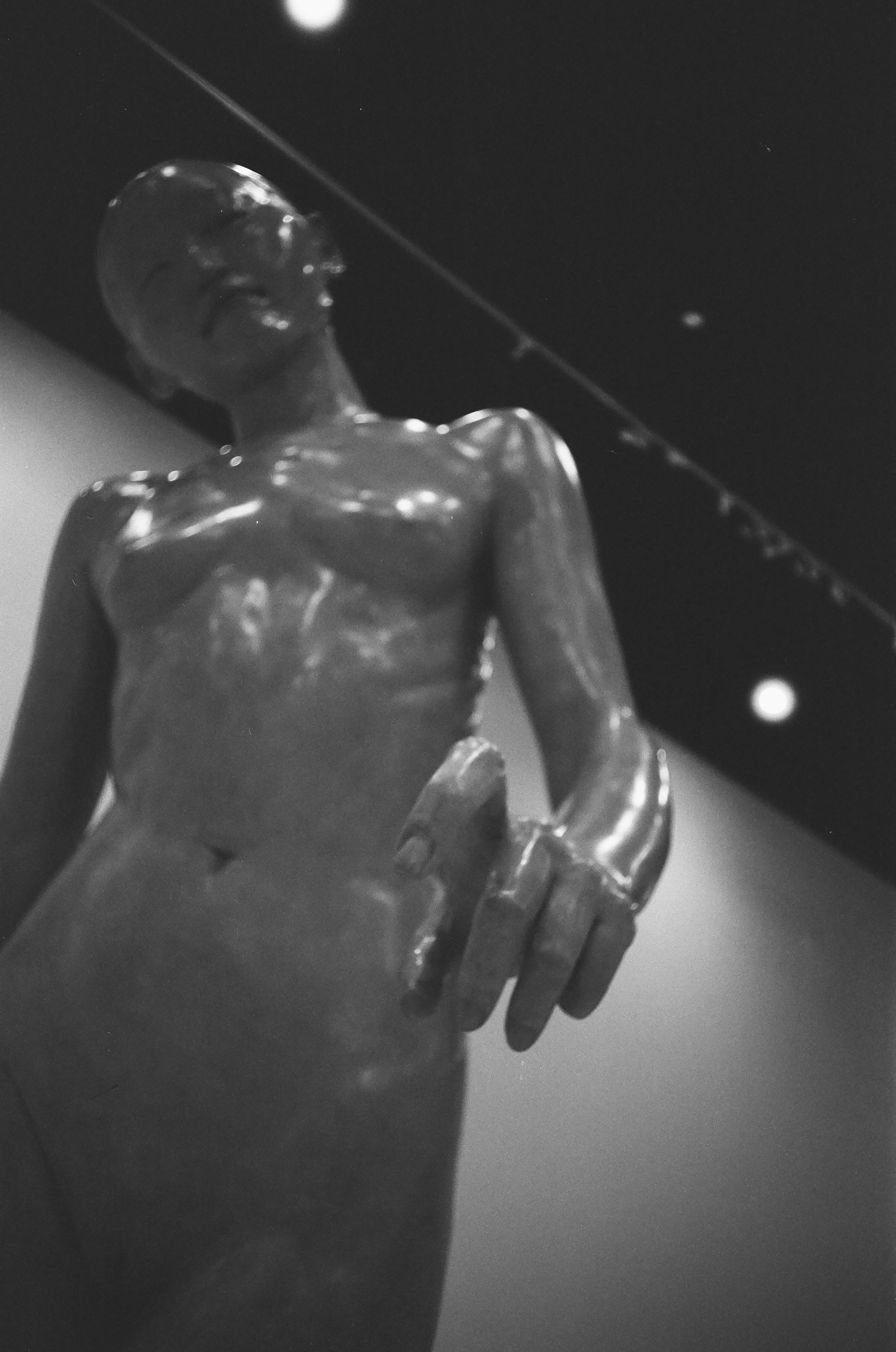 Gesture of statues: a silent, downcast gaze in metallic monochrome