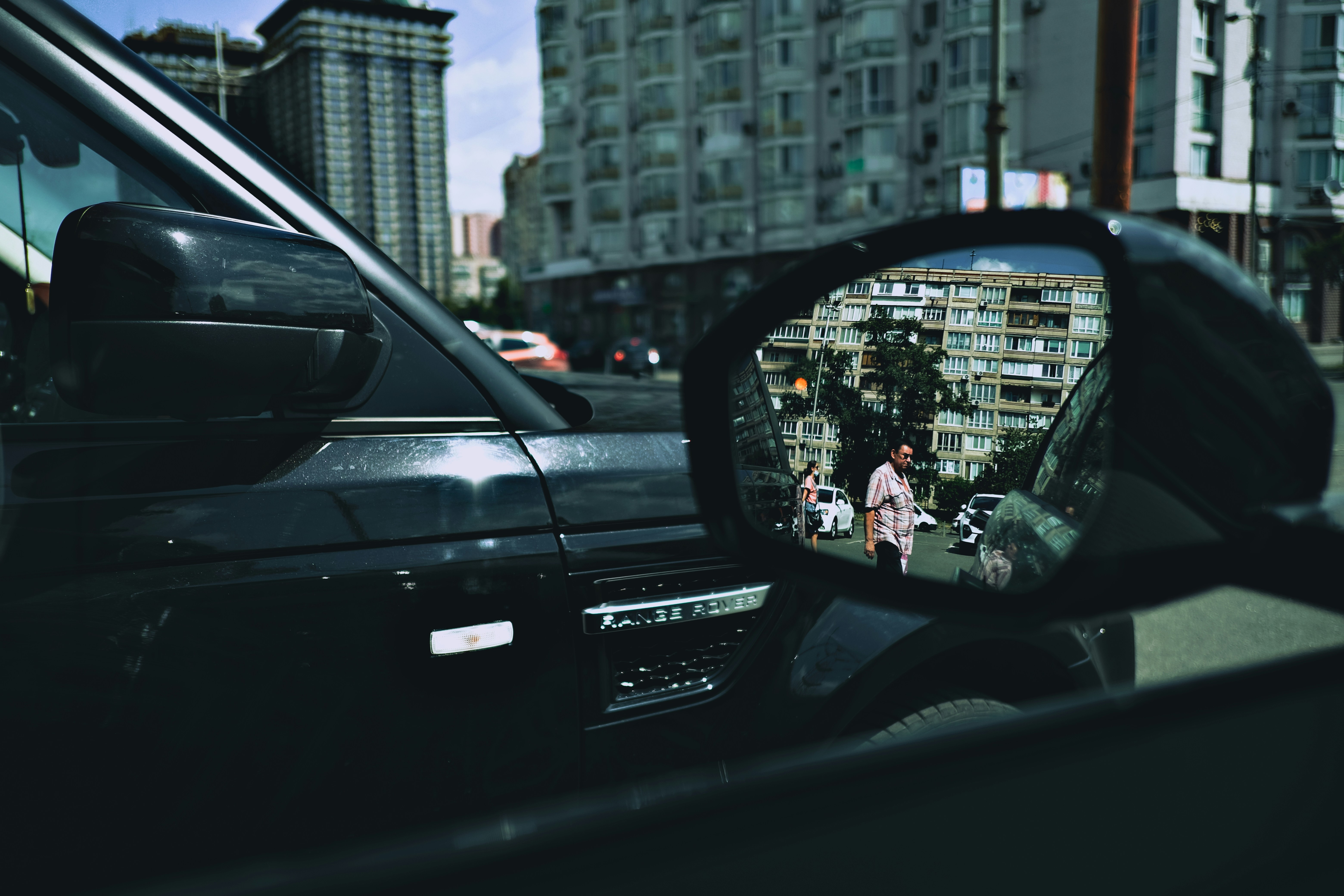 Reflected Figure: A Pedestrian Framed by a City Side Mirror
