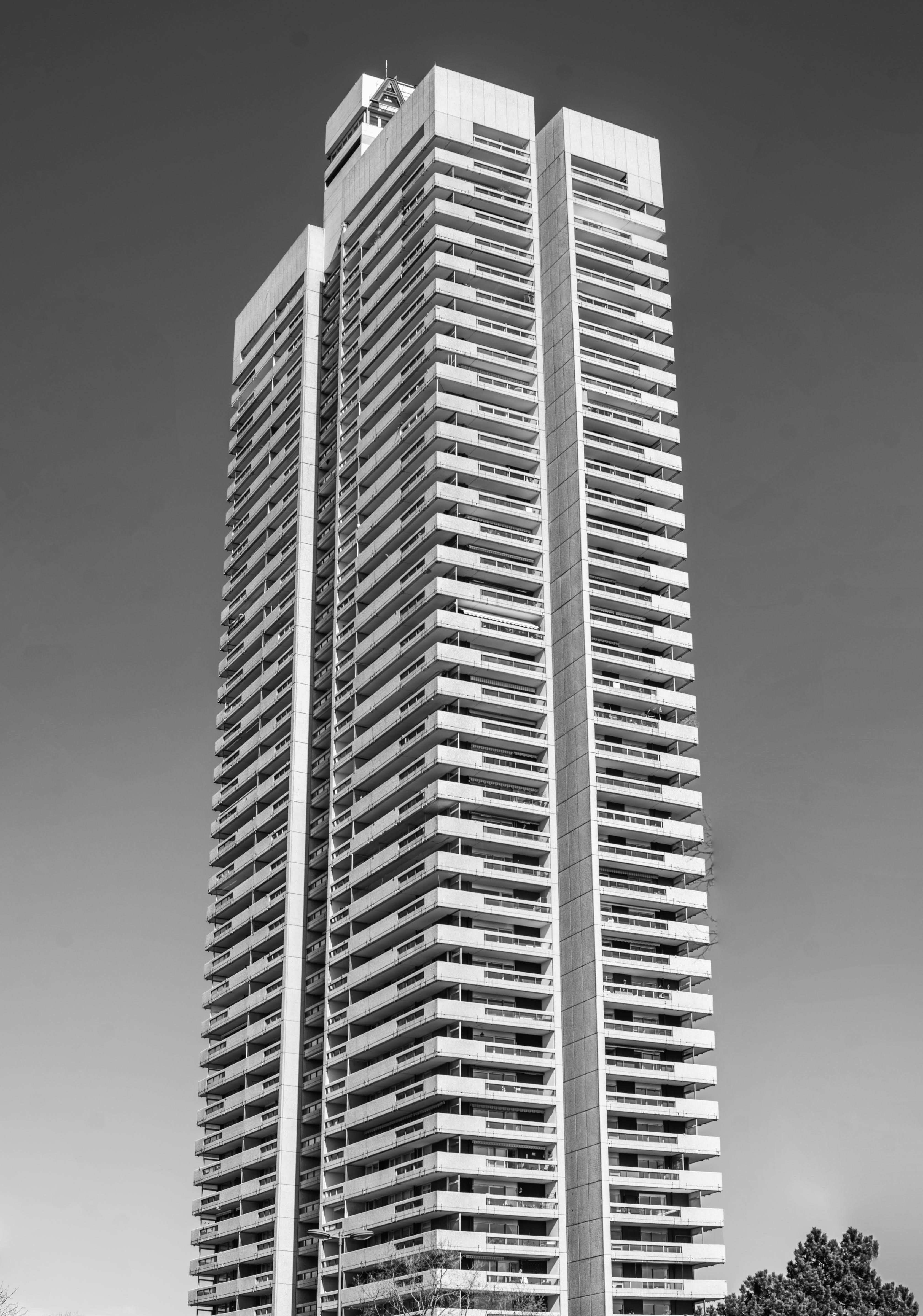 A sleek high-rise building showcases modern architectural design with prominent horizontal and vertical lines against a clear sky.