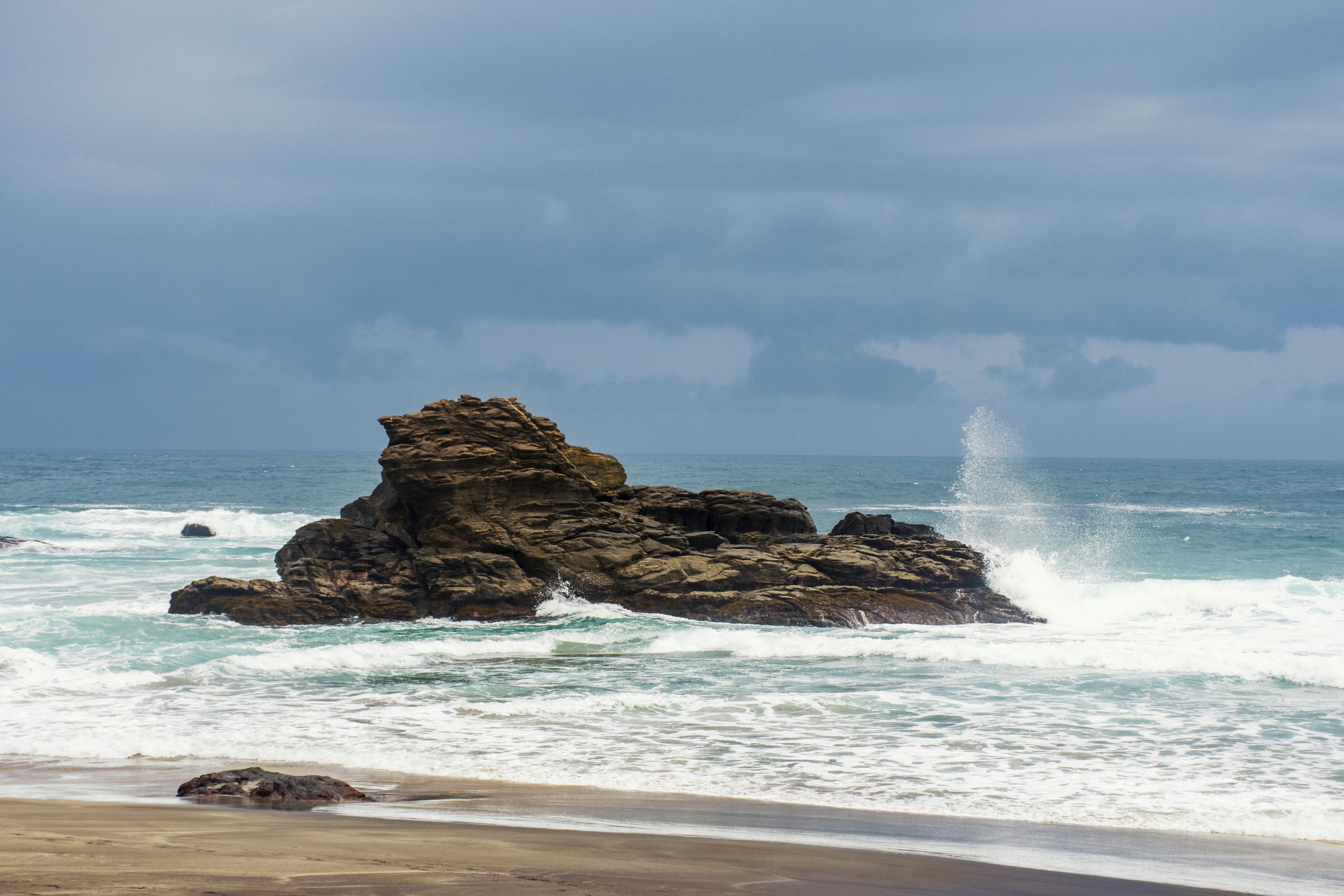 Waves Clash Against Weathered Rocks