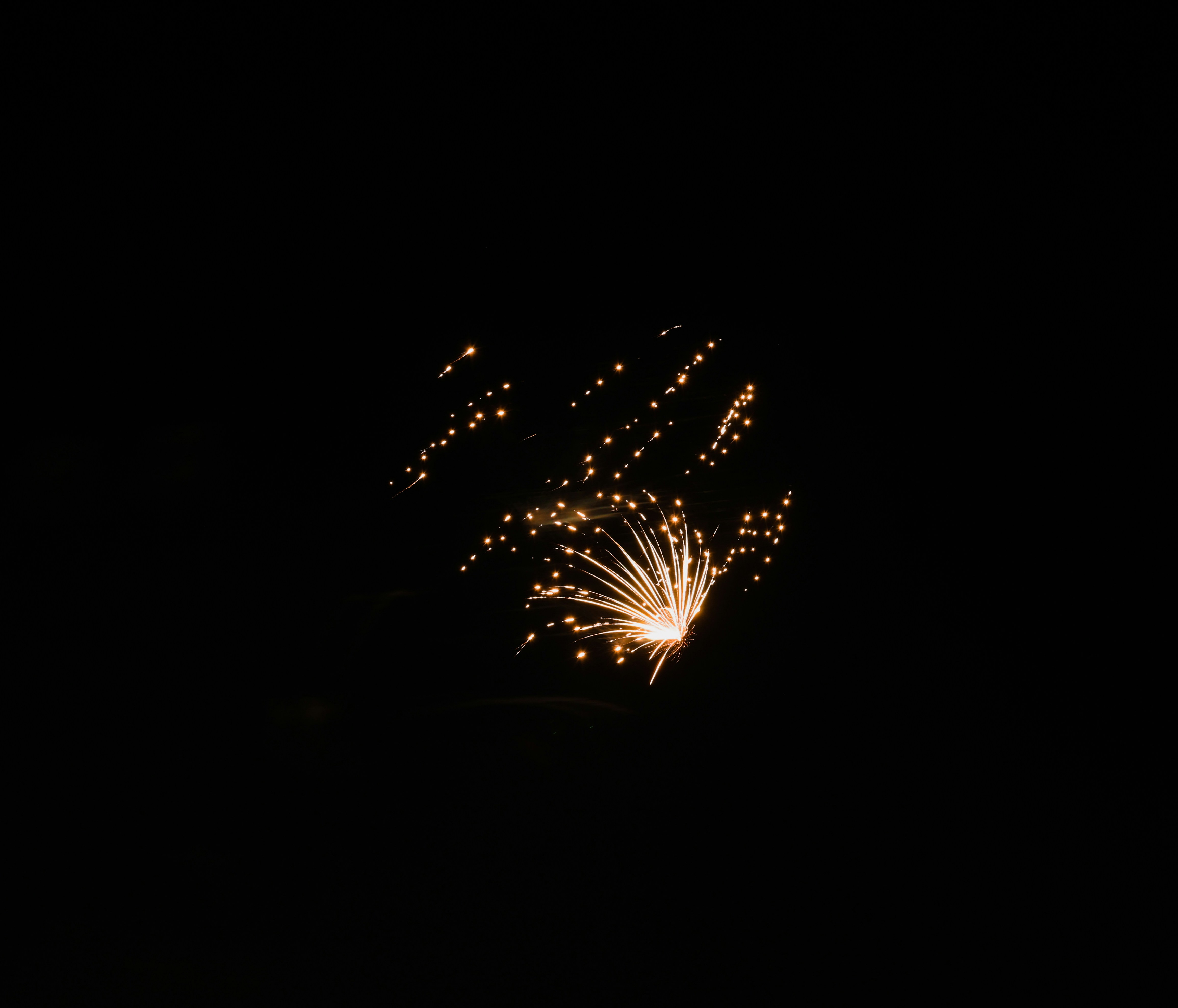 Firework explosion illuminating the night sky, with sparks radiating outward in a captivating display of light.