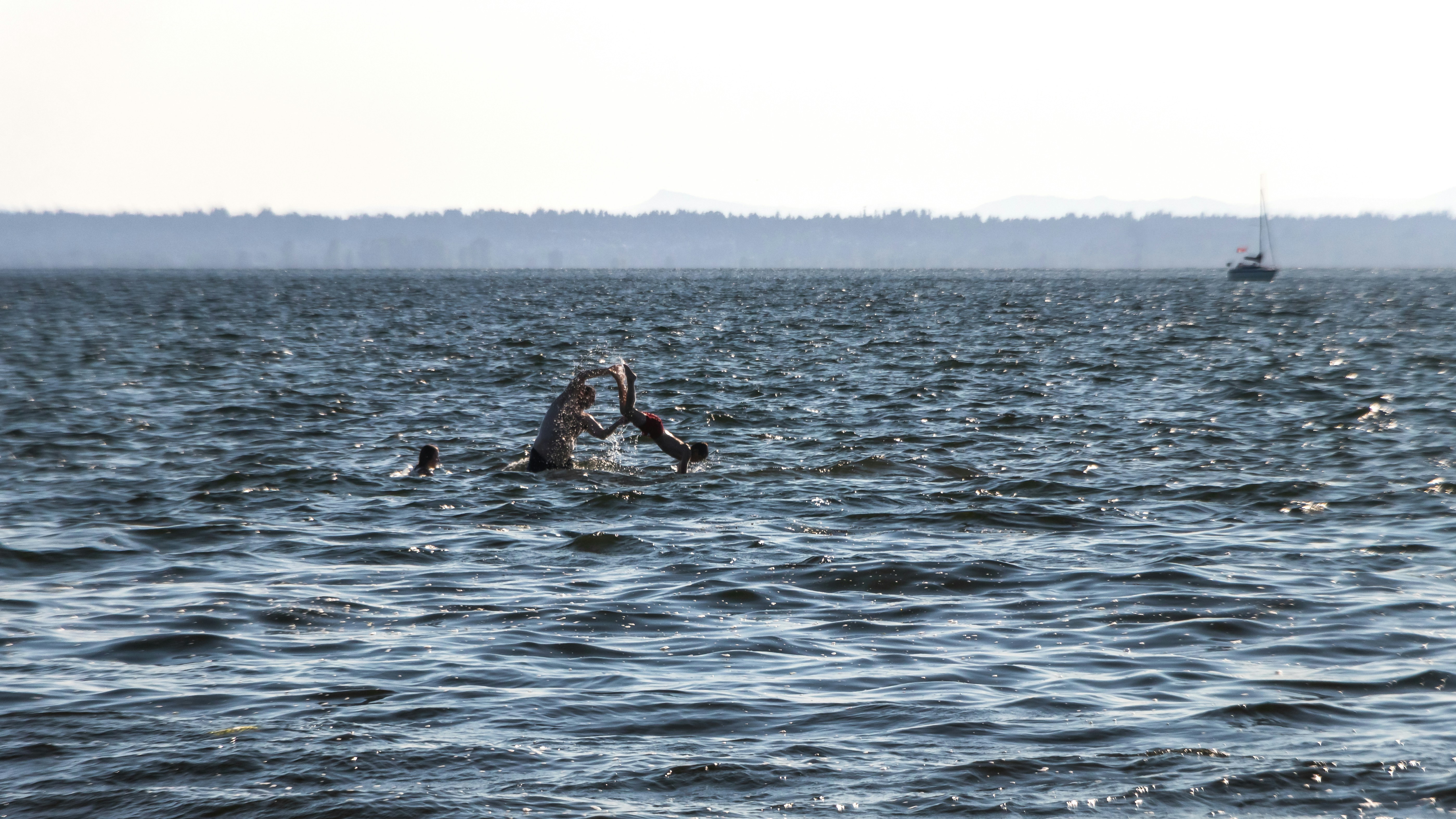 Tug-of-War at Sea: Silhouettes and Splashes in the Distant Horizon