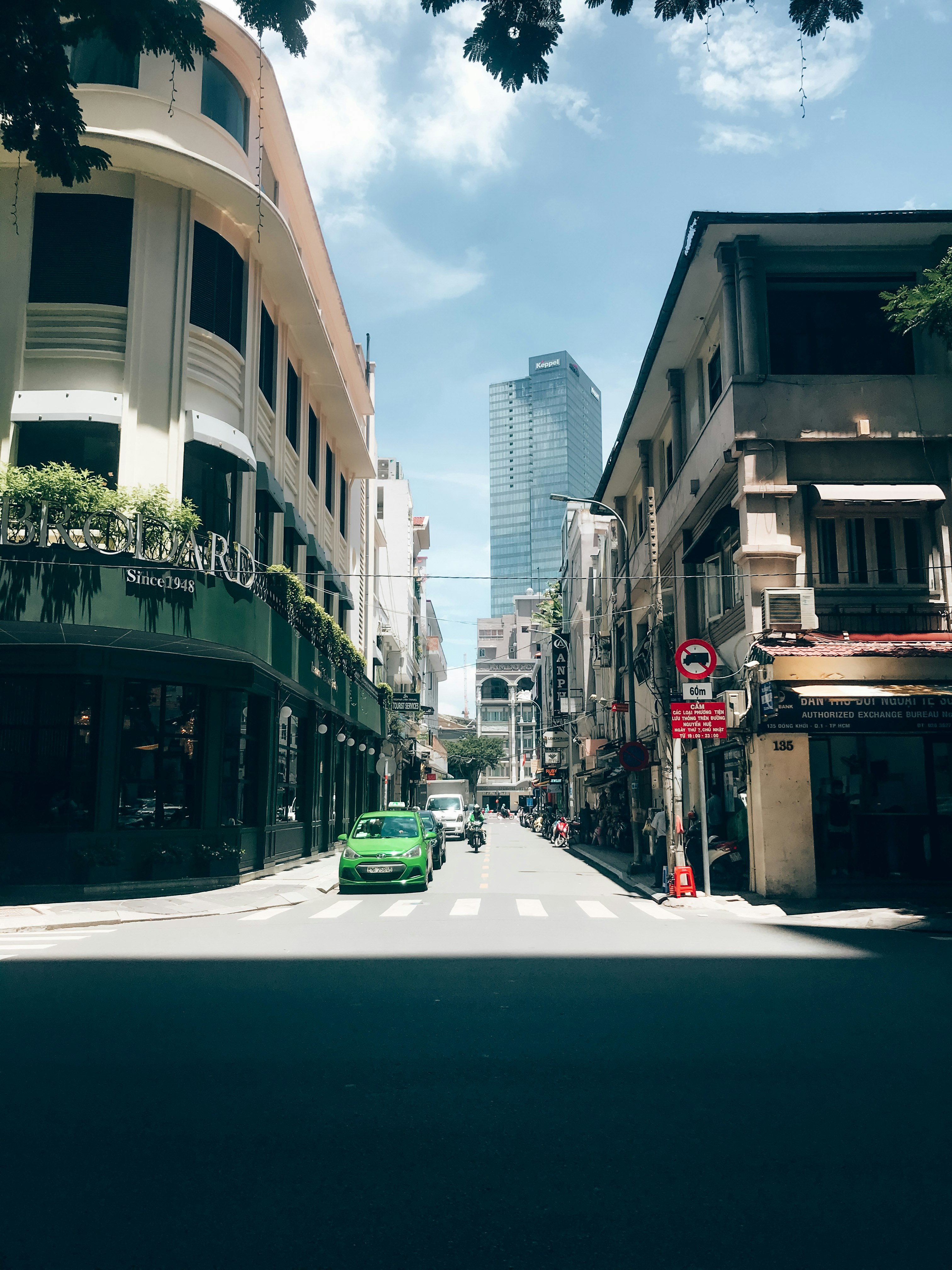 Cars parked on side of the road in between buildings during daytime ...
