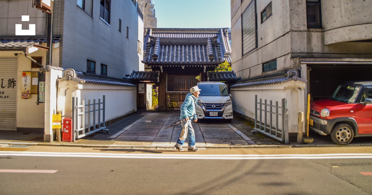 白いシャツとブルーデニムのジーンズを着た男性が昼間、道路を自転車で走っているの写真 Unsplashの京都の無料画像
