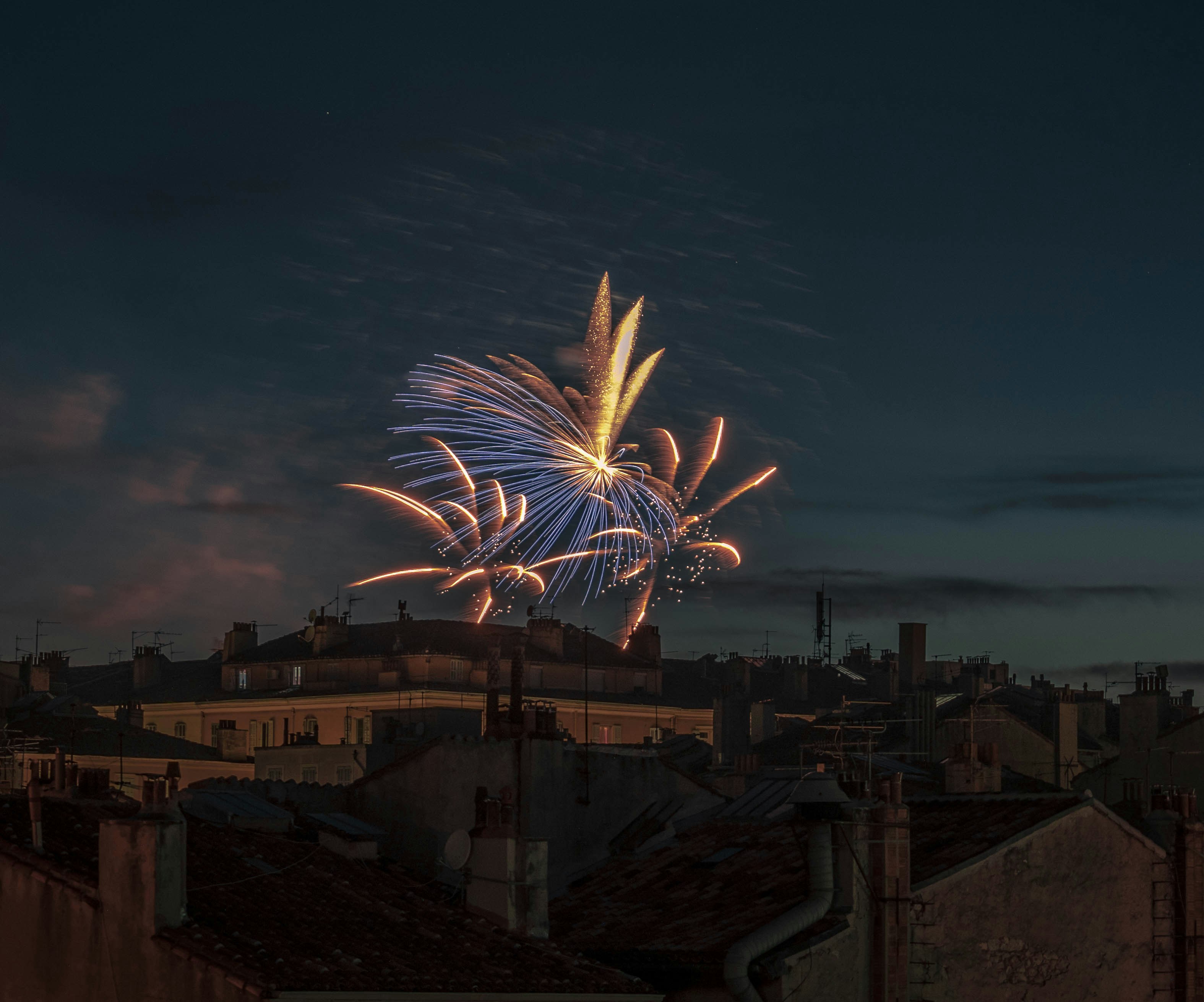 Urban Nightscape Fireworks: Sparks Over Quiet Rooftops
