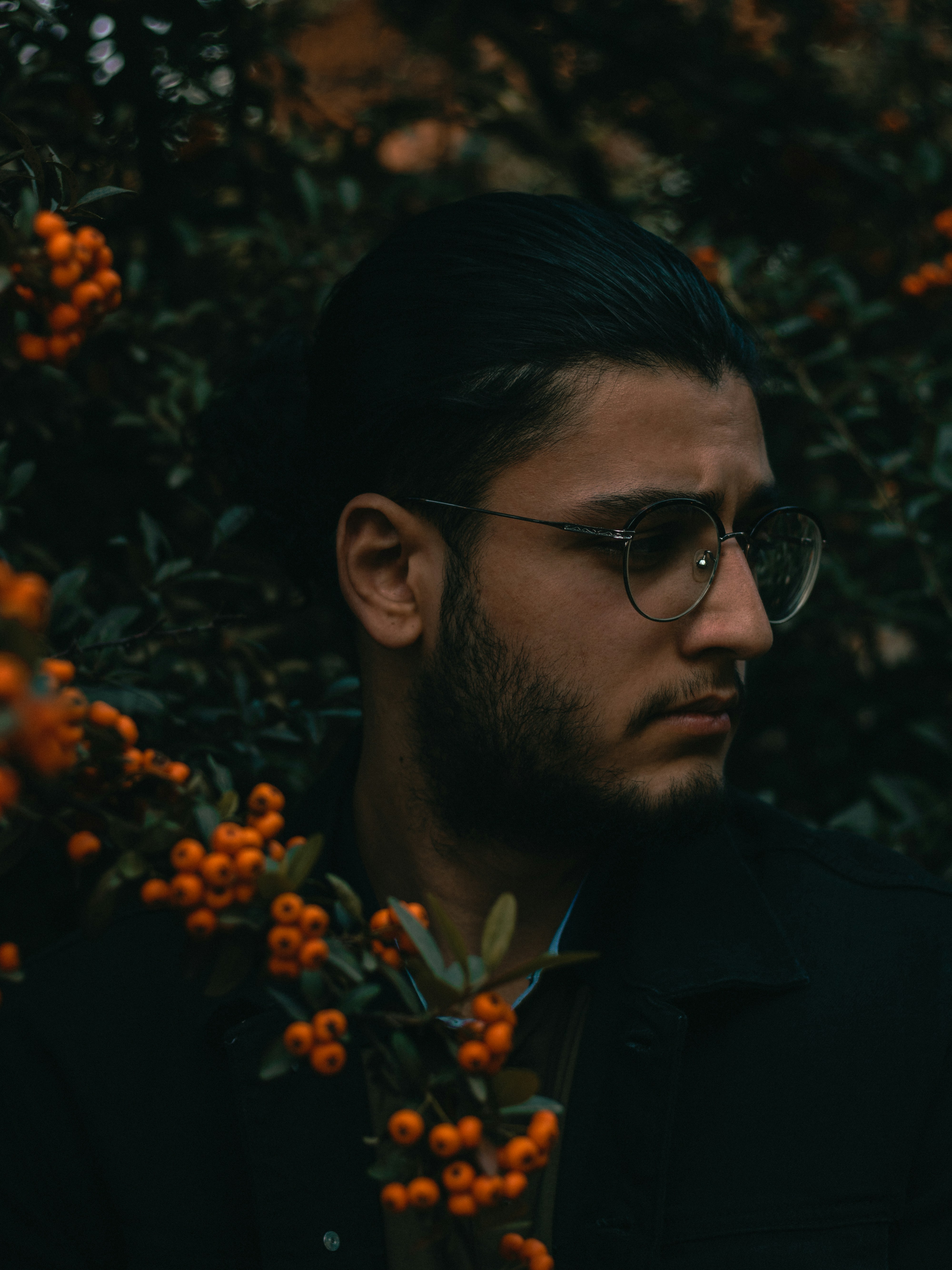 Noir Portrait: A Quiet Gaze Among Orange Berries