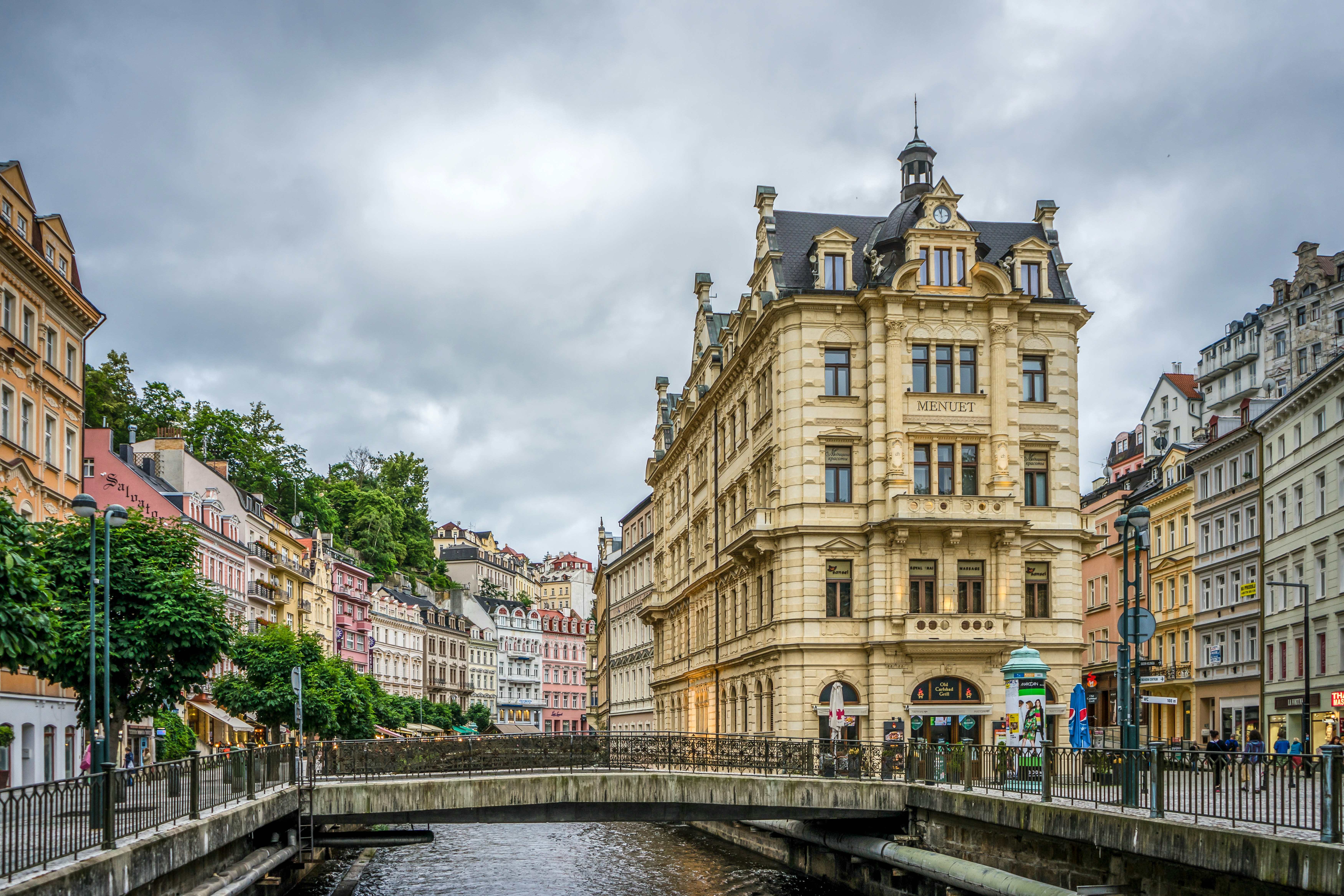 Brown concrete building near bridge under white sky during daytime ...