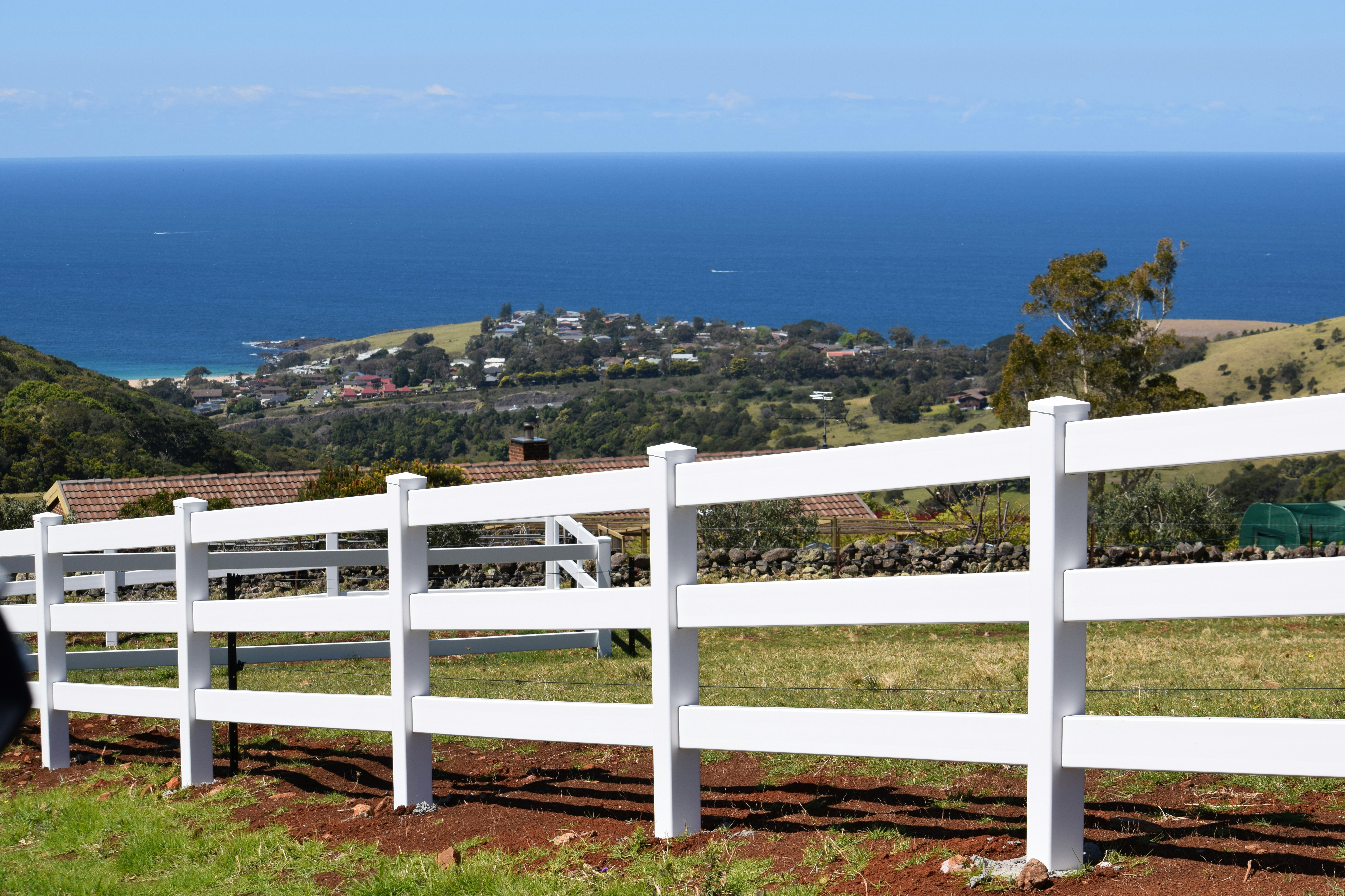 Coastal Ridge Over White Fence: A Seaside Village Vista