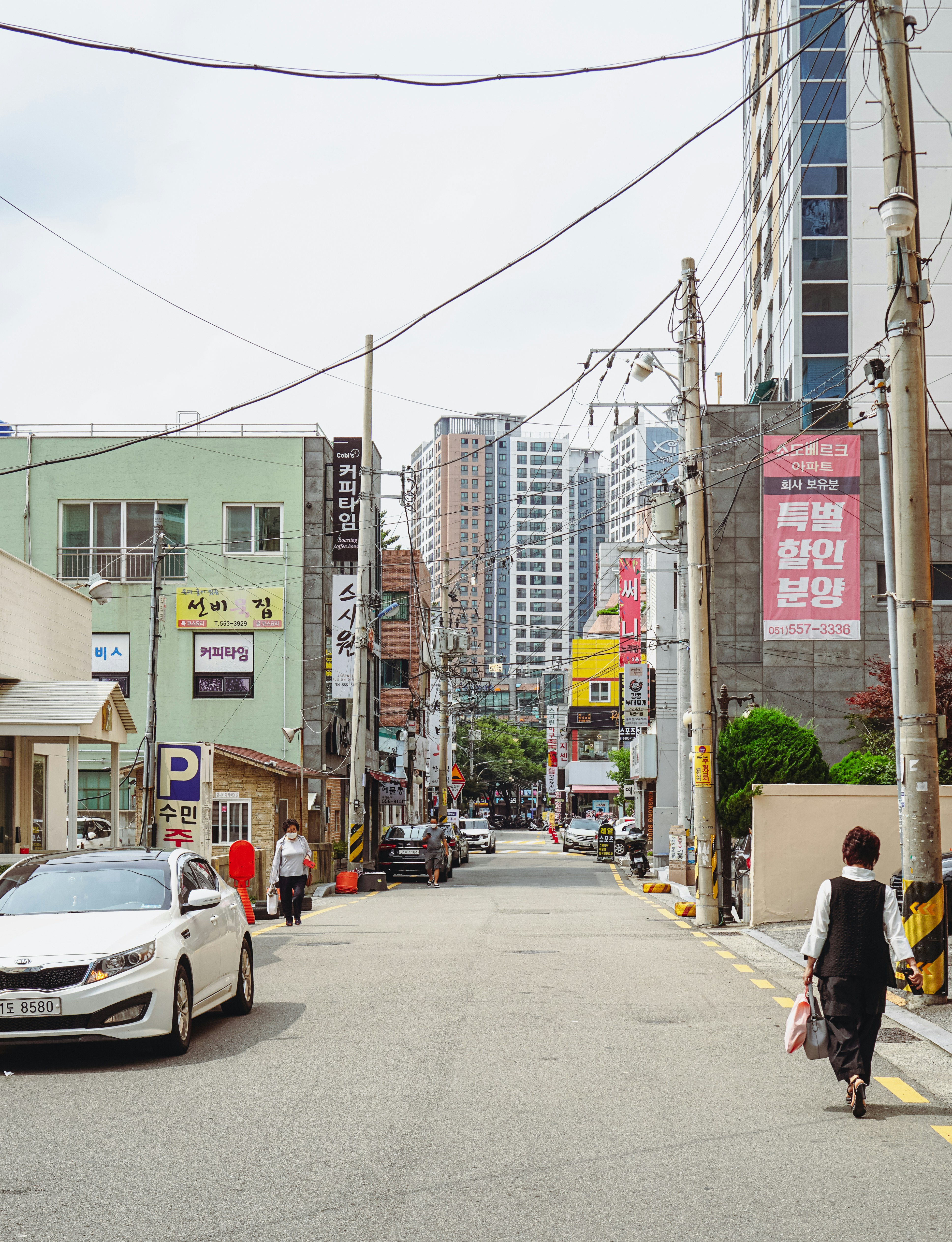 woman in black jacket walking on sidewalk during daytime