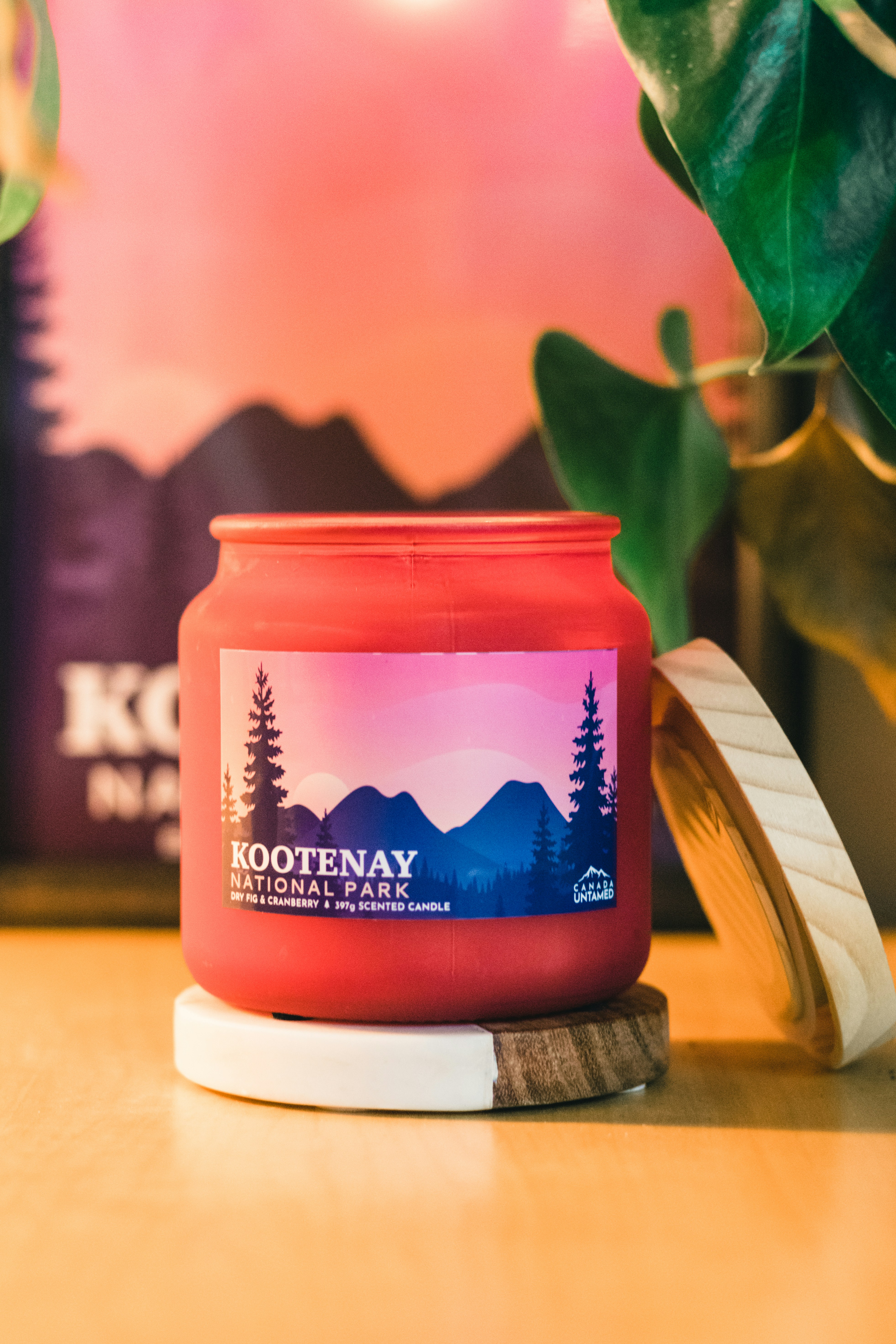 Kootenay Glow: Mountain Sunset Candle on a Wooden Coaster