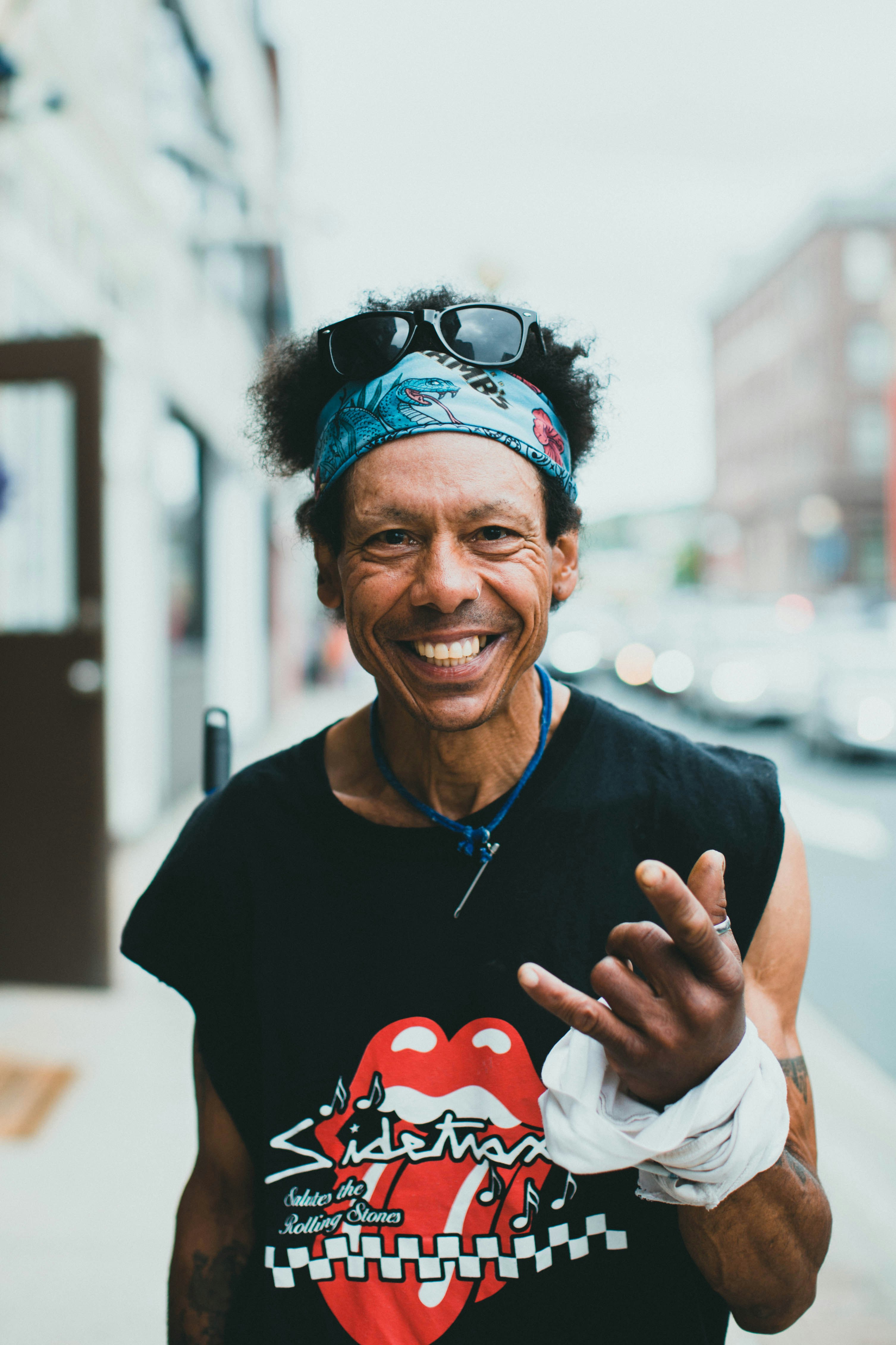 Blue-Bandana Street Portrait: Warm Smile on a City Sidewalk
