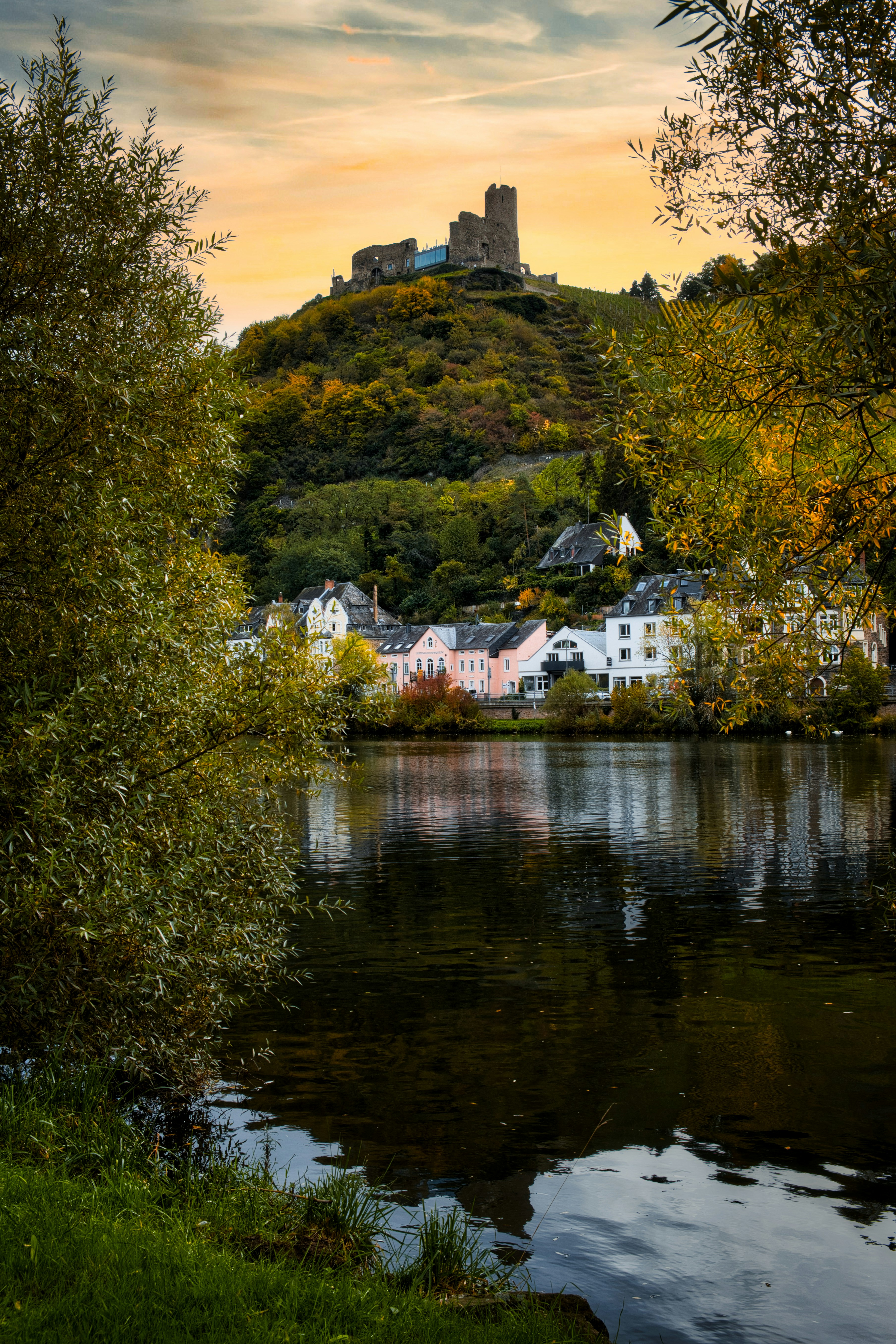 Hilltop Castle at Sunset: Watchful Ruins Over a Riverside Village
