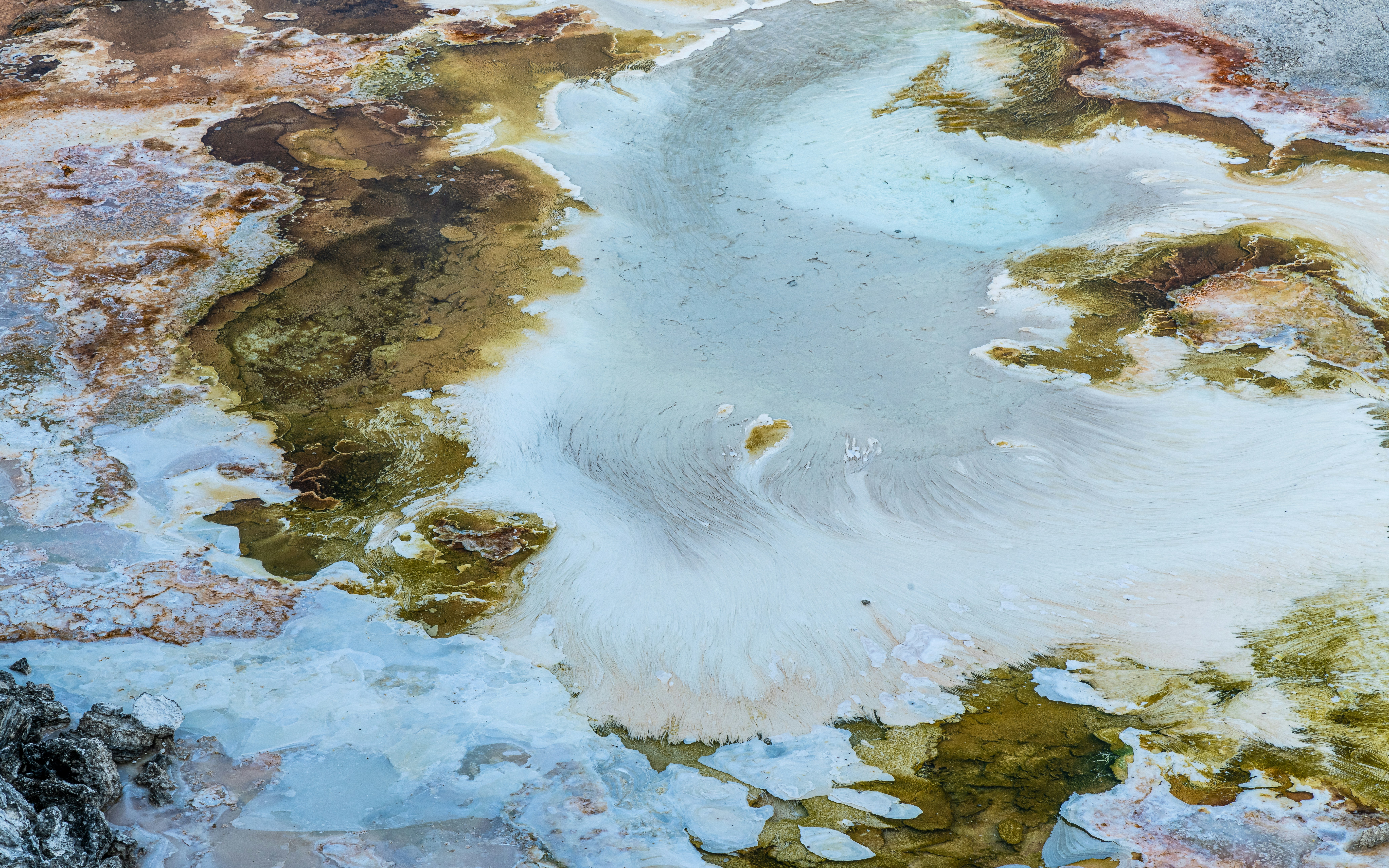 Swirling patterns of mineral deposits in soft blues and ochres.