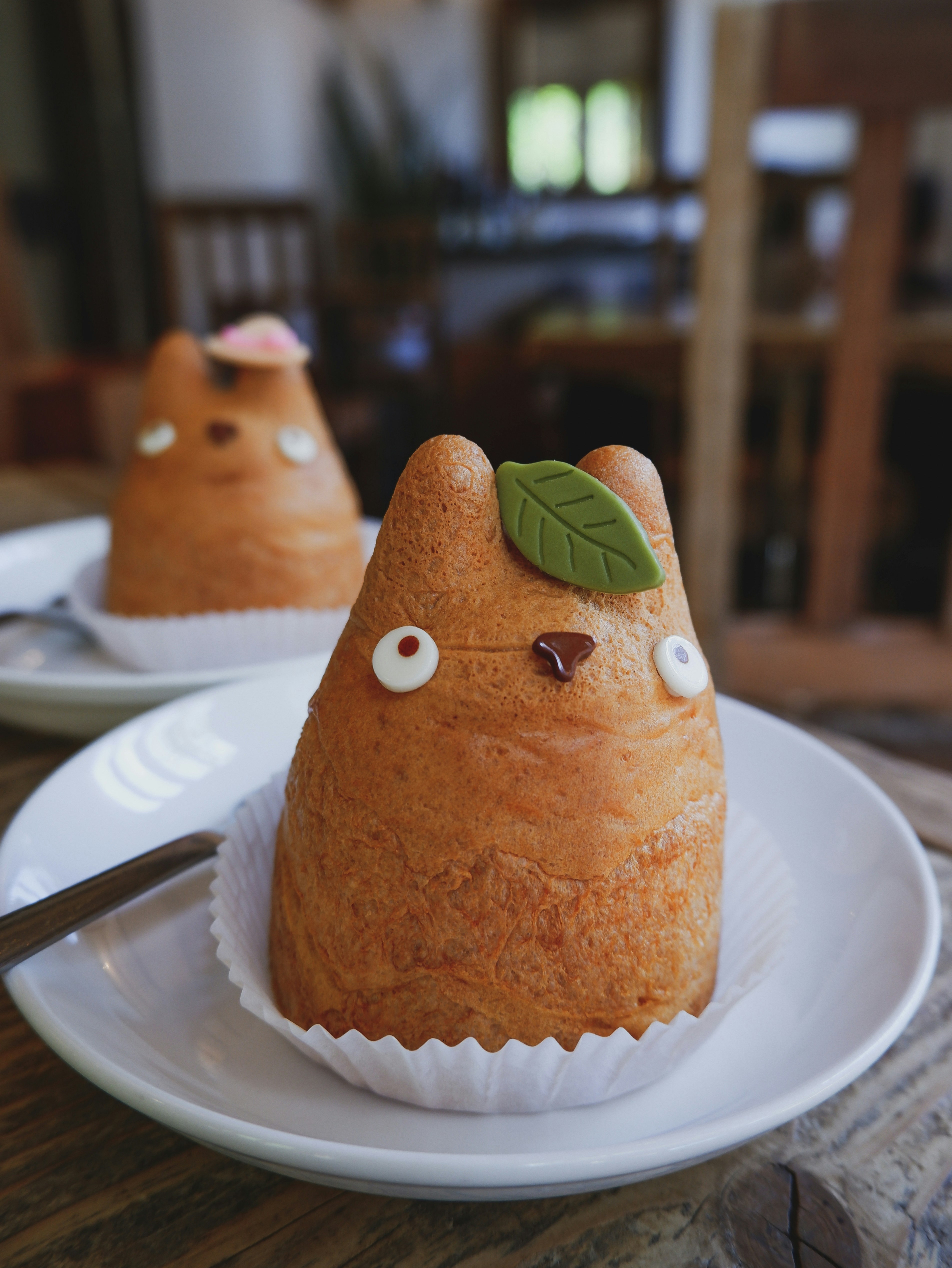 Adorable pastry shaped like a cute animal, adorned with playful decorations and set on a white plate. The inviting atmosphere enhances the charm of this delightful dessert.