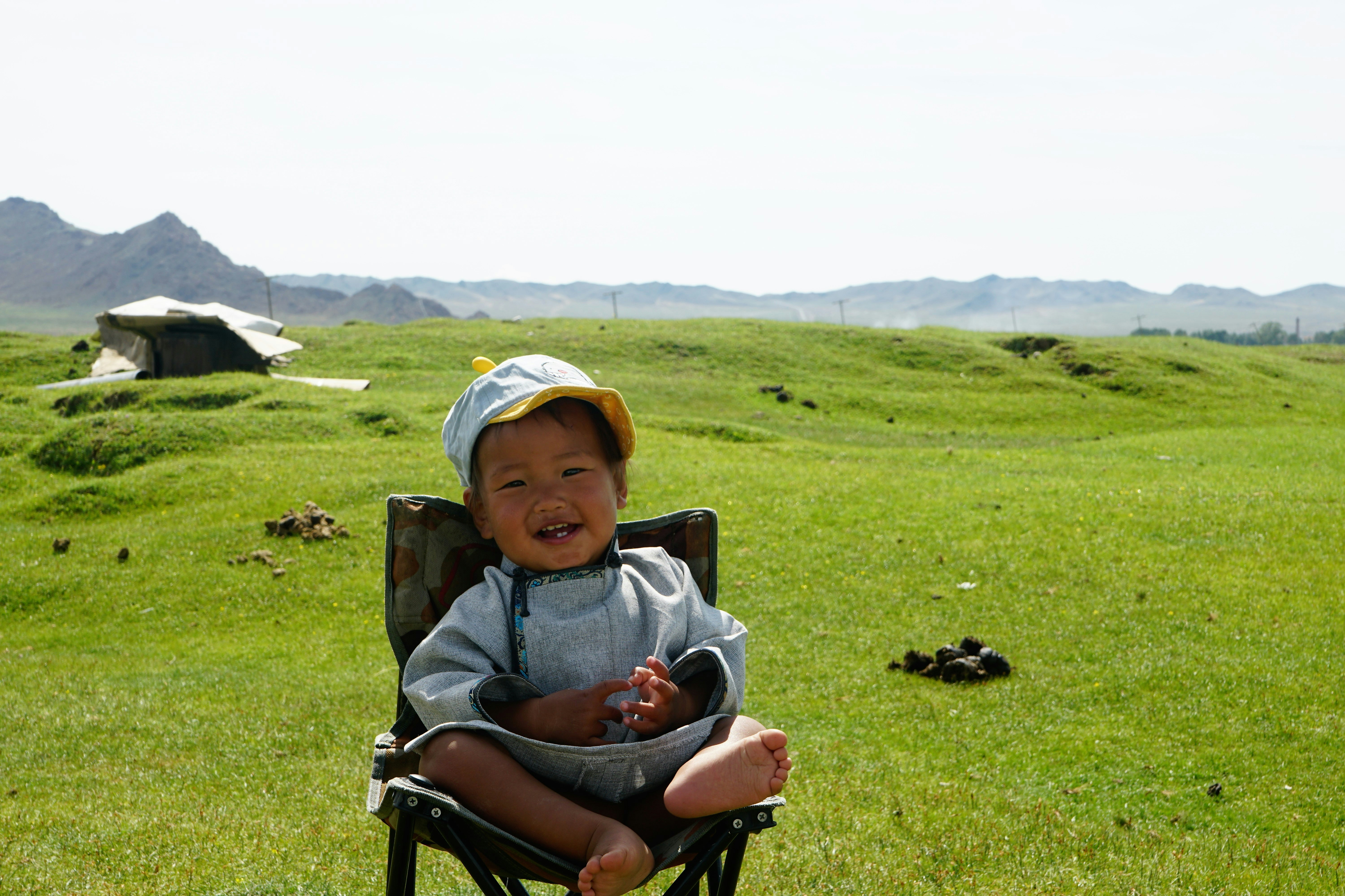 Joy in a Wide Grassland: A Baby's Sunlit Moment