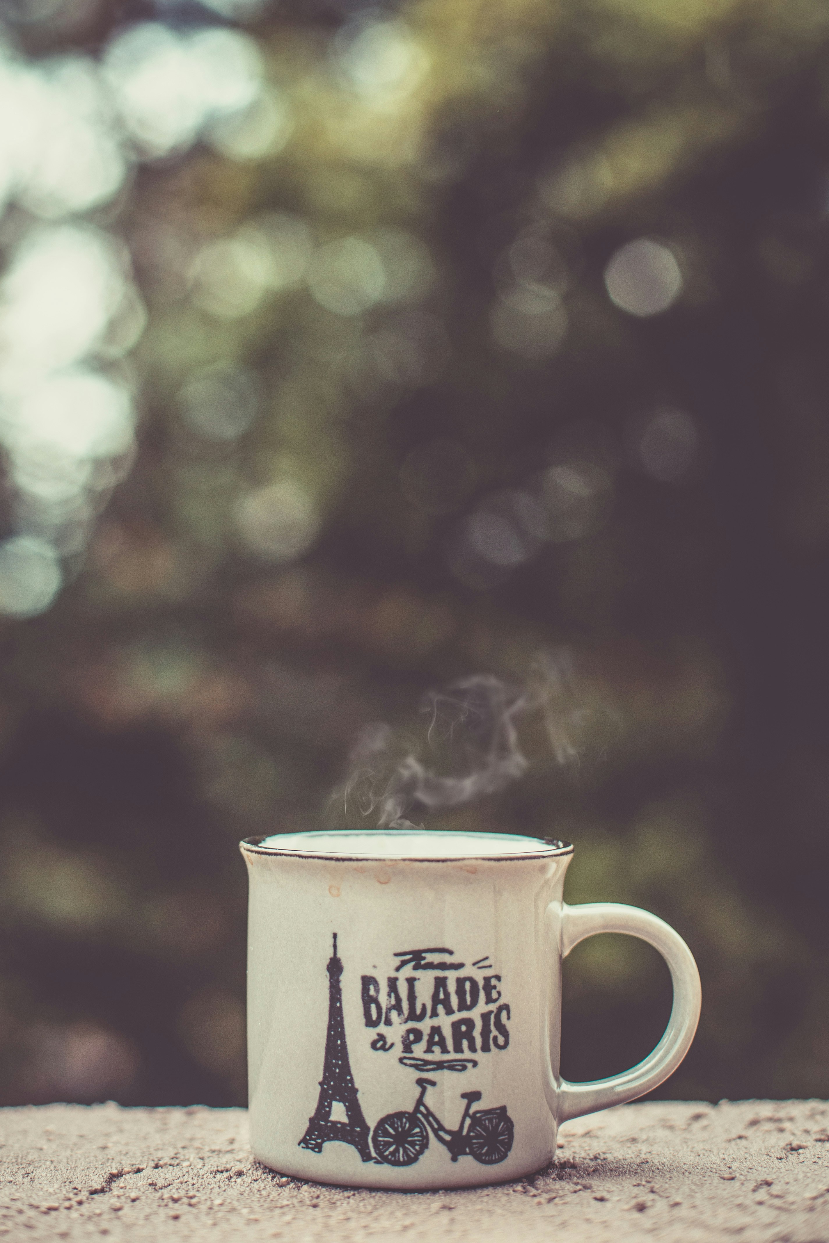 Paris in a Cup: Steam Rises from a Paris-Themed Mug on a Quiet Terrace
