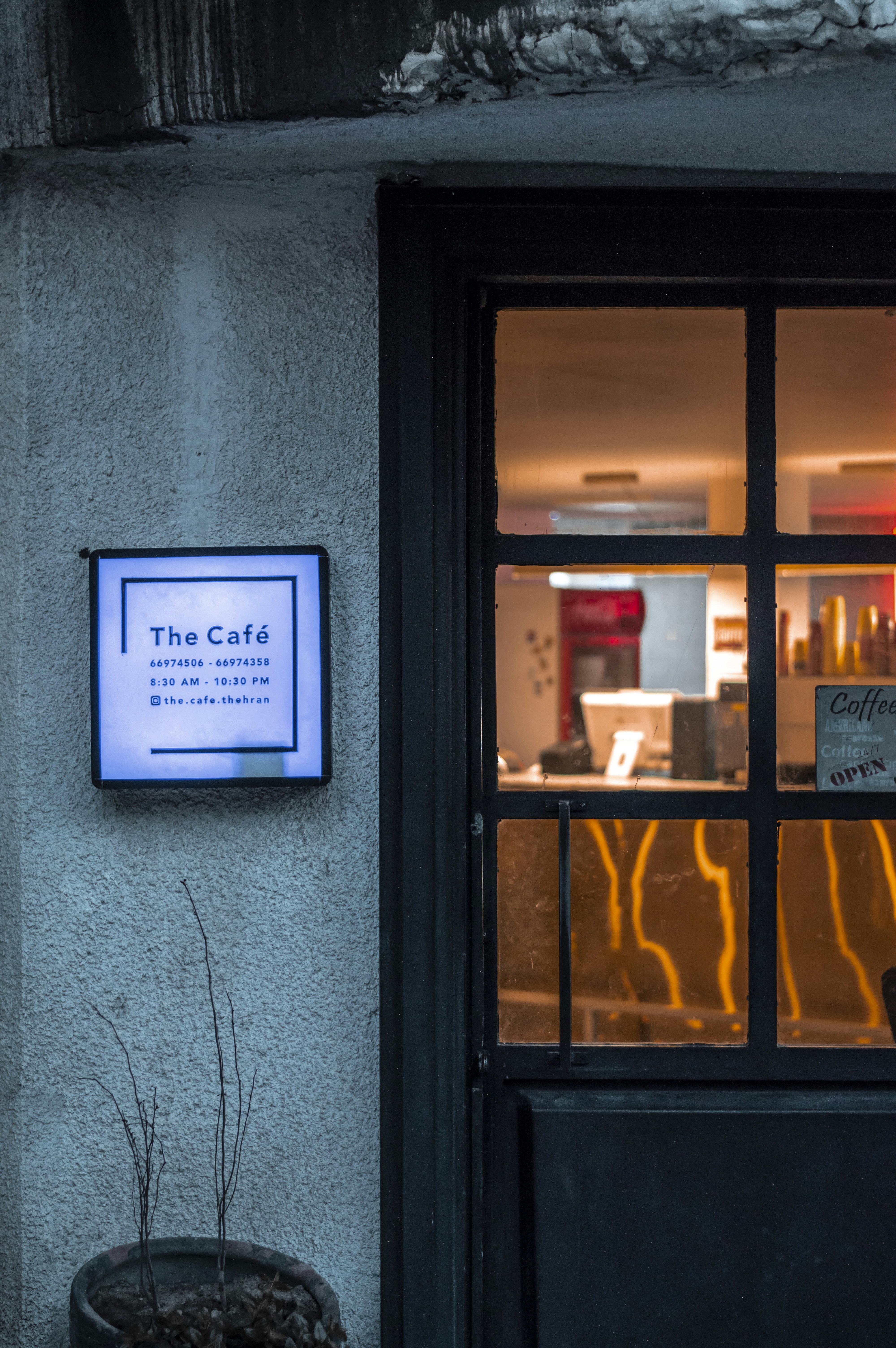 Blue Neon Sign Beckoning a Warm Café Window at Dusk