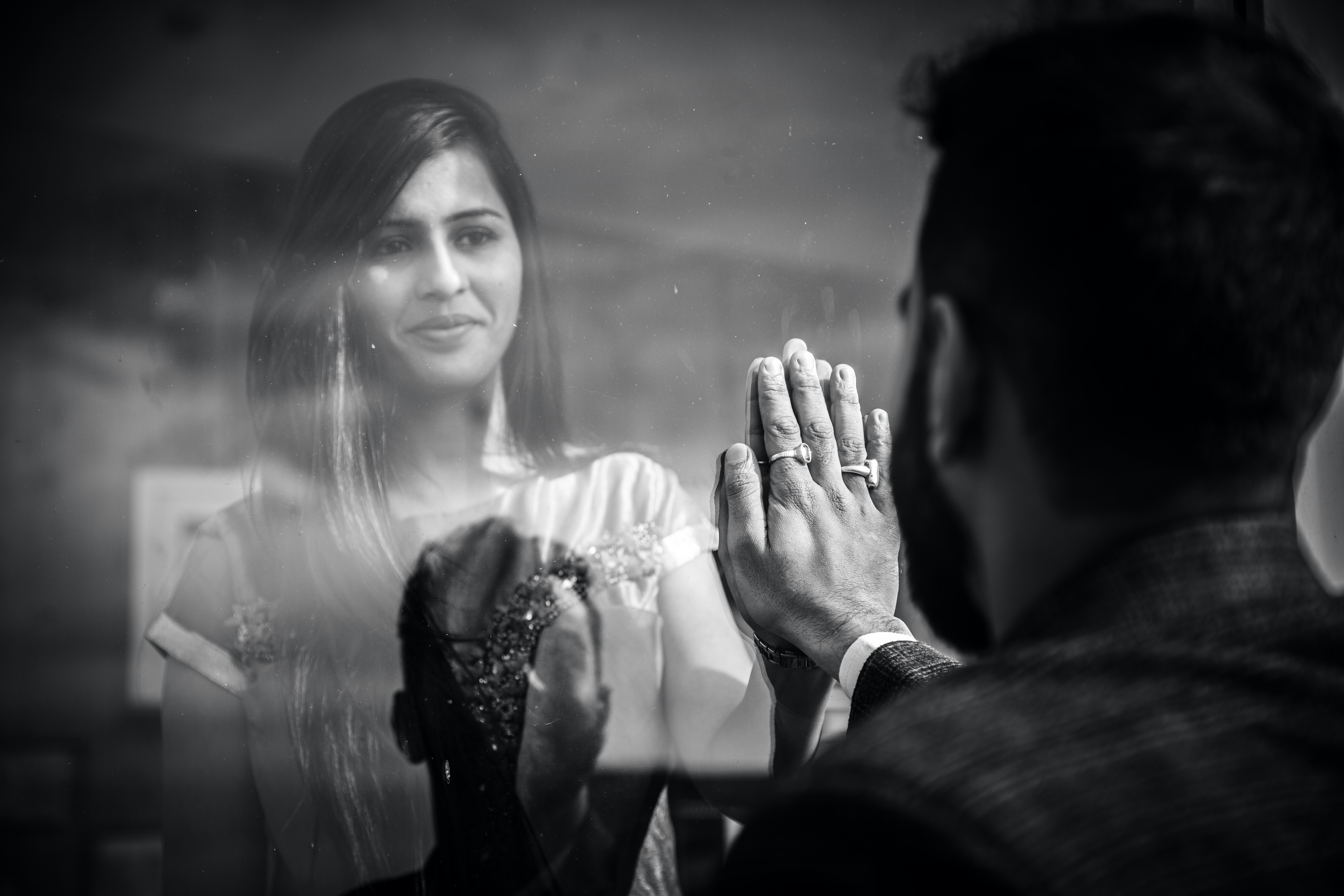 Through the Glass: Hands and Faces in a Quiet Reflection