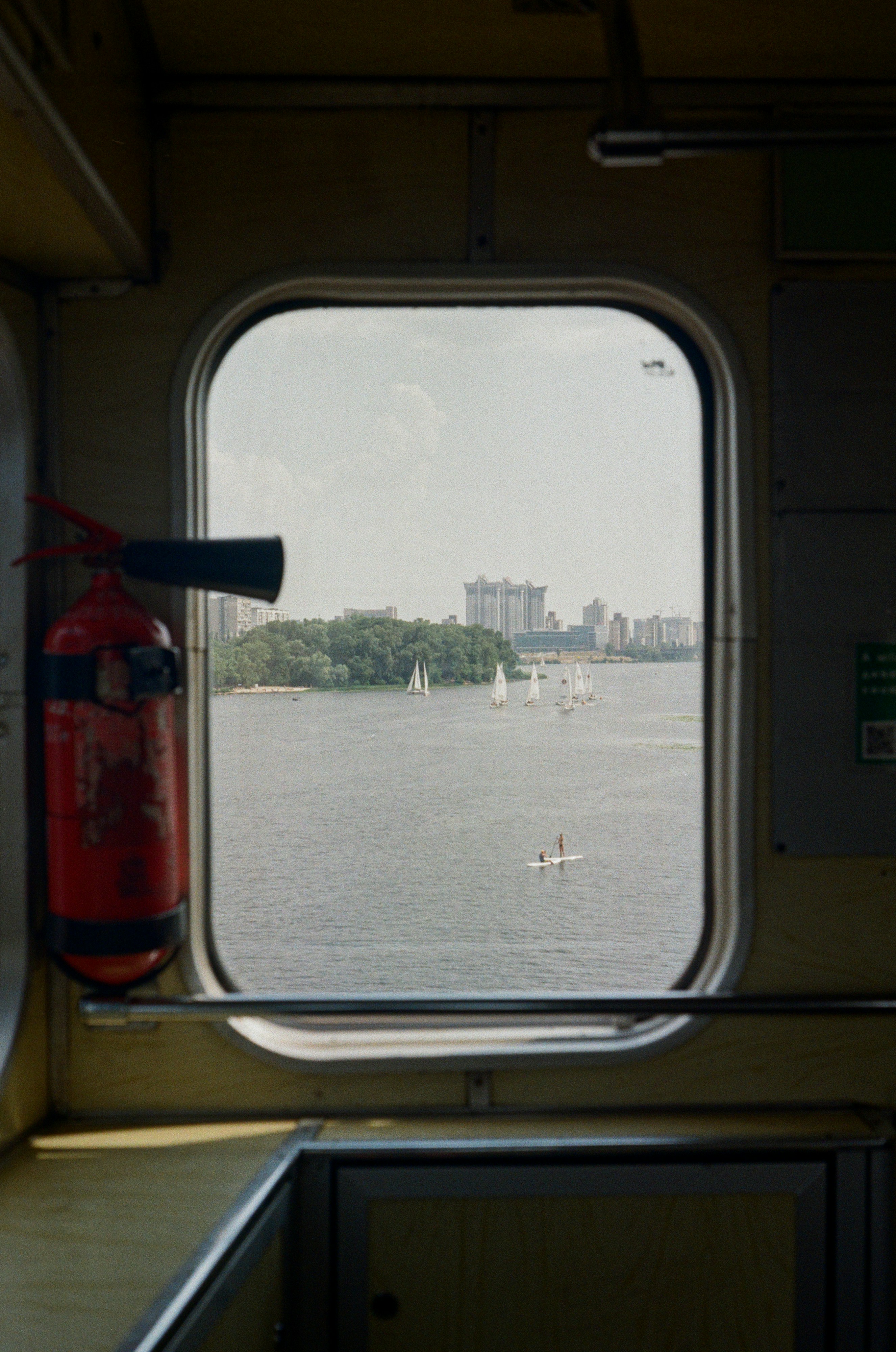 Window to the River: Sailboats and Skyline Framed by a Vessel's Interior