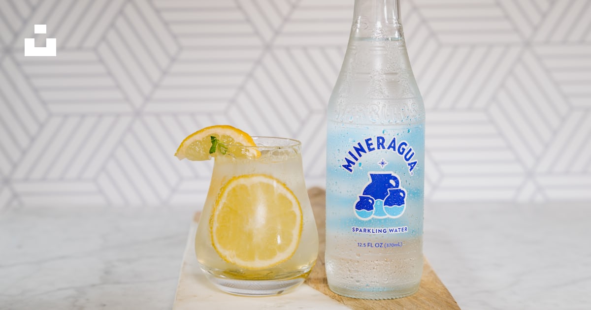 Blue And White Labeled Bottle Beside Clear Drinking Glass Photo Free