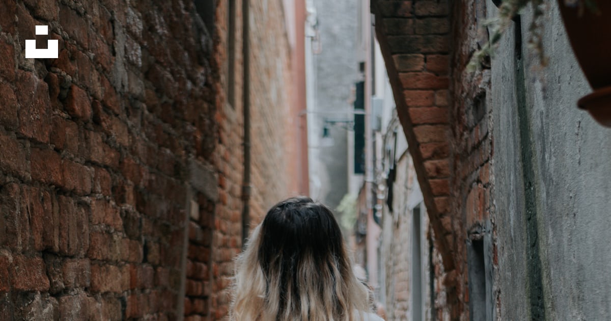 Foto Mujer Vestida De Blanco Parada En Una Pared De Ladrillos De
