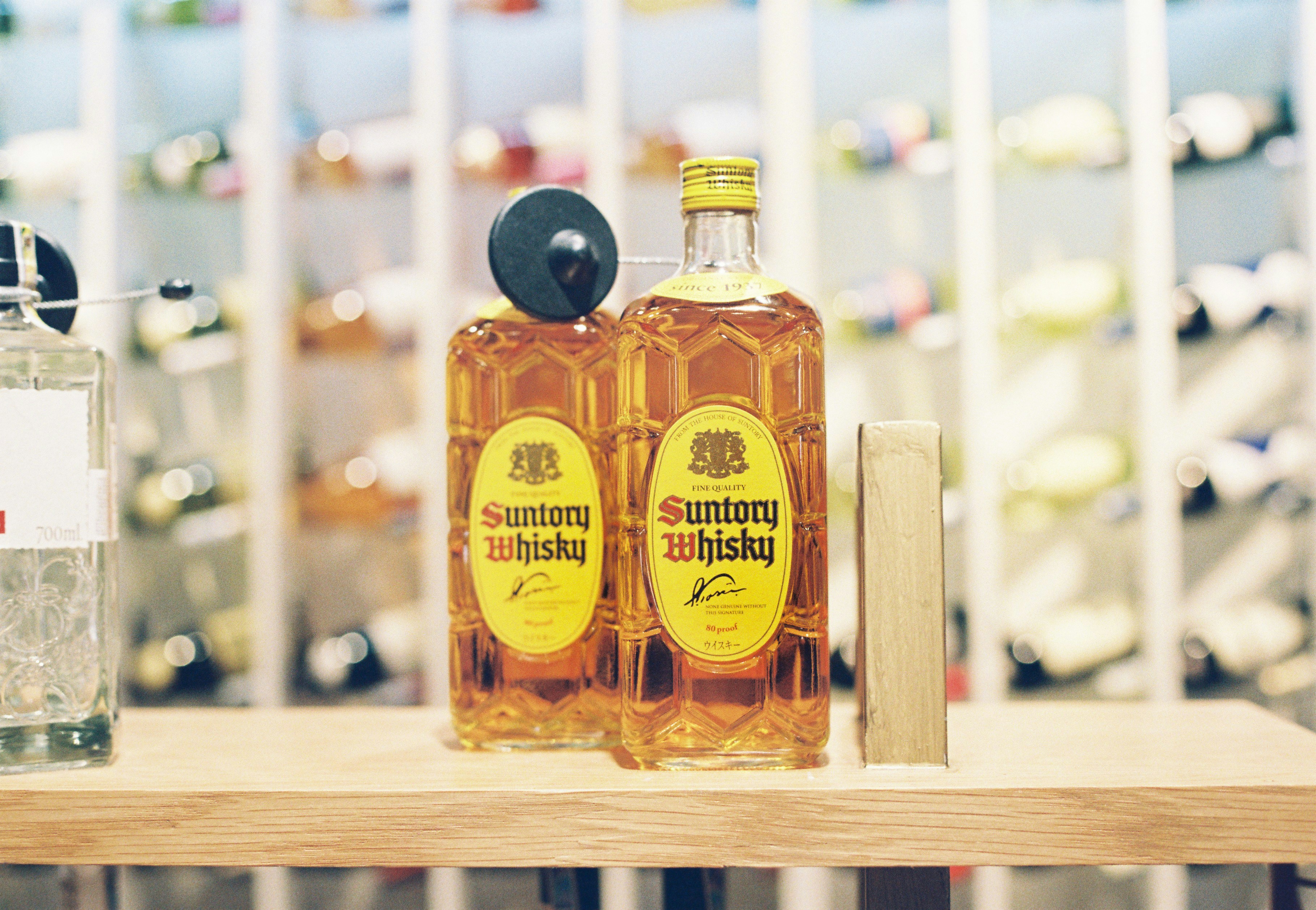 Amber twins: Suntory Whisky Bottles on a Well-Lit Bar Shelf