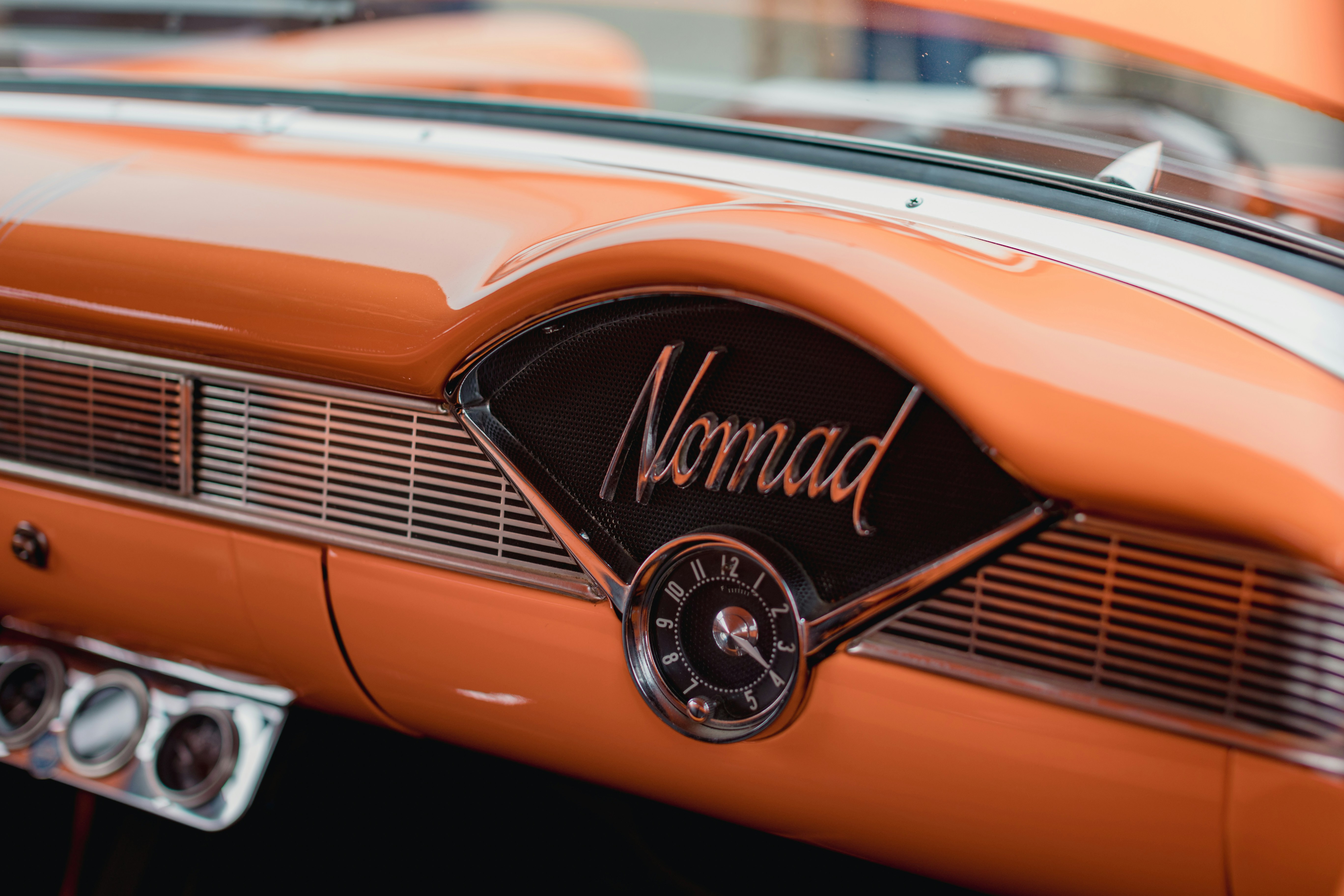 Amber Nomad Emblem Gleaming on a Sunlit 1950s Chevrolet Front End