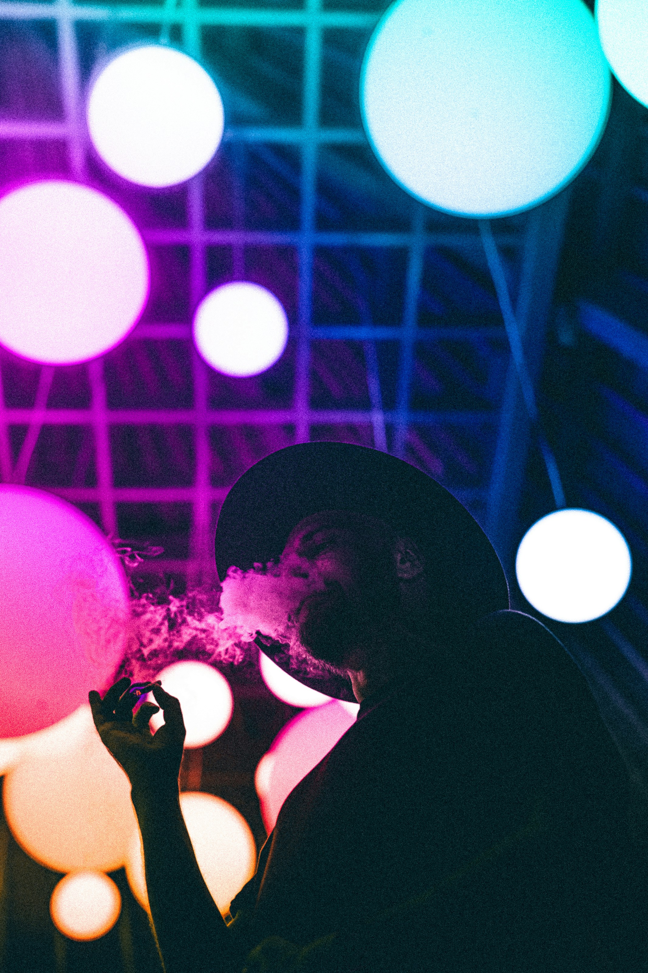 Silhouette of a person exhaling smoke under a canopy of vibrant, glowing orbs, creating a surreal atmosphere.