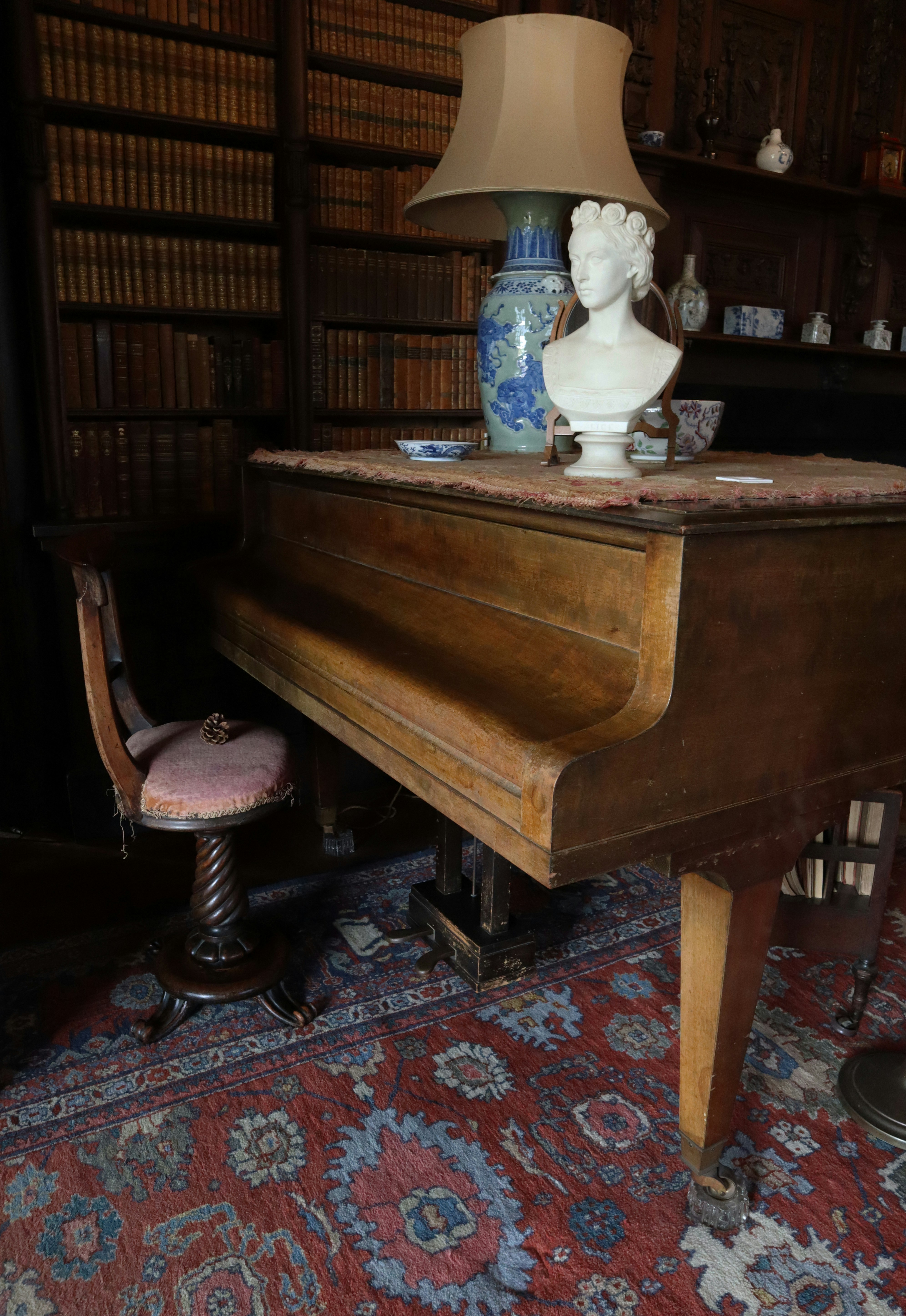 Brown wooden upright piano with white ceramic figurine on top photo ...