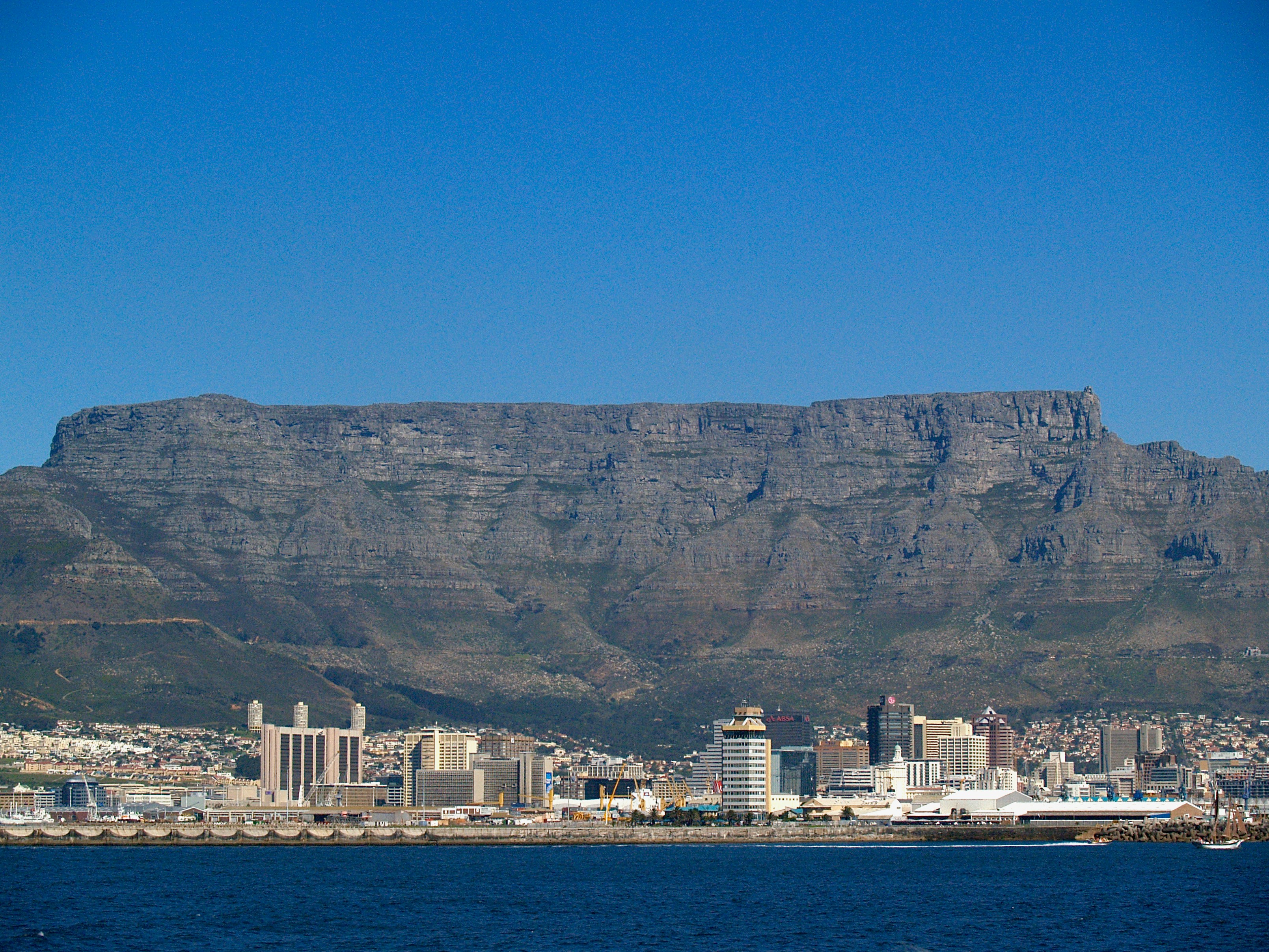 View of Cape Town with Table Mountain in the background from the sea | white and brown buildings on brown mountain near body of water during daytime