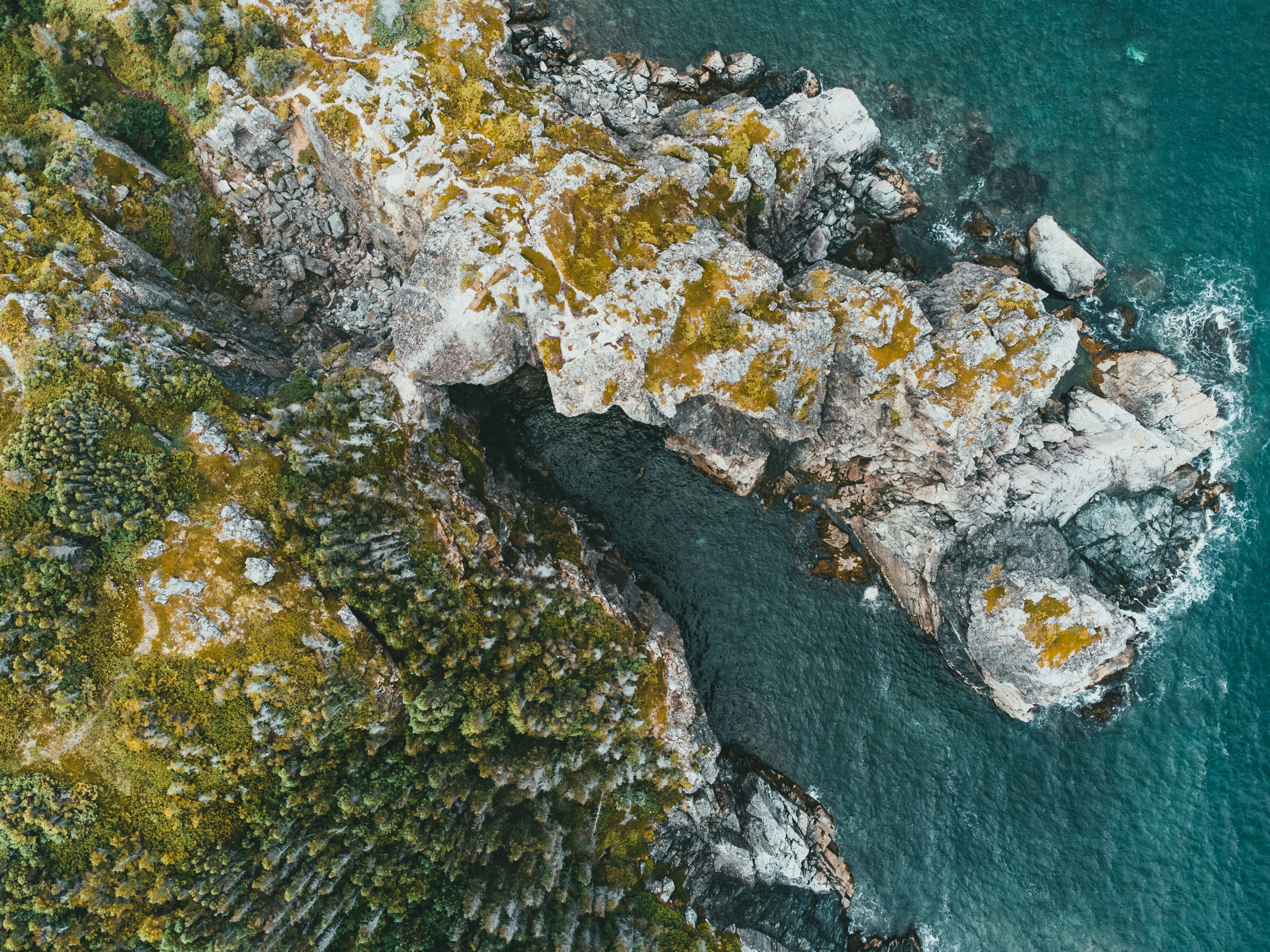 White and brown rock formation beside blue sea during daytime photo ...