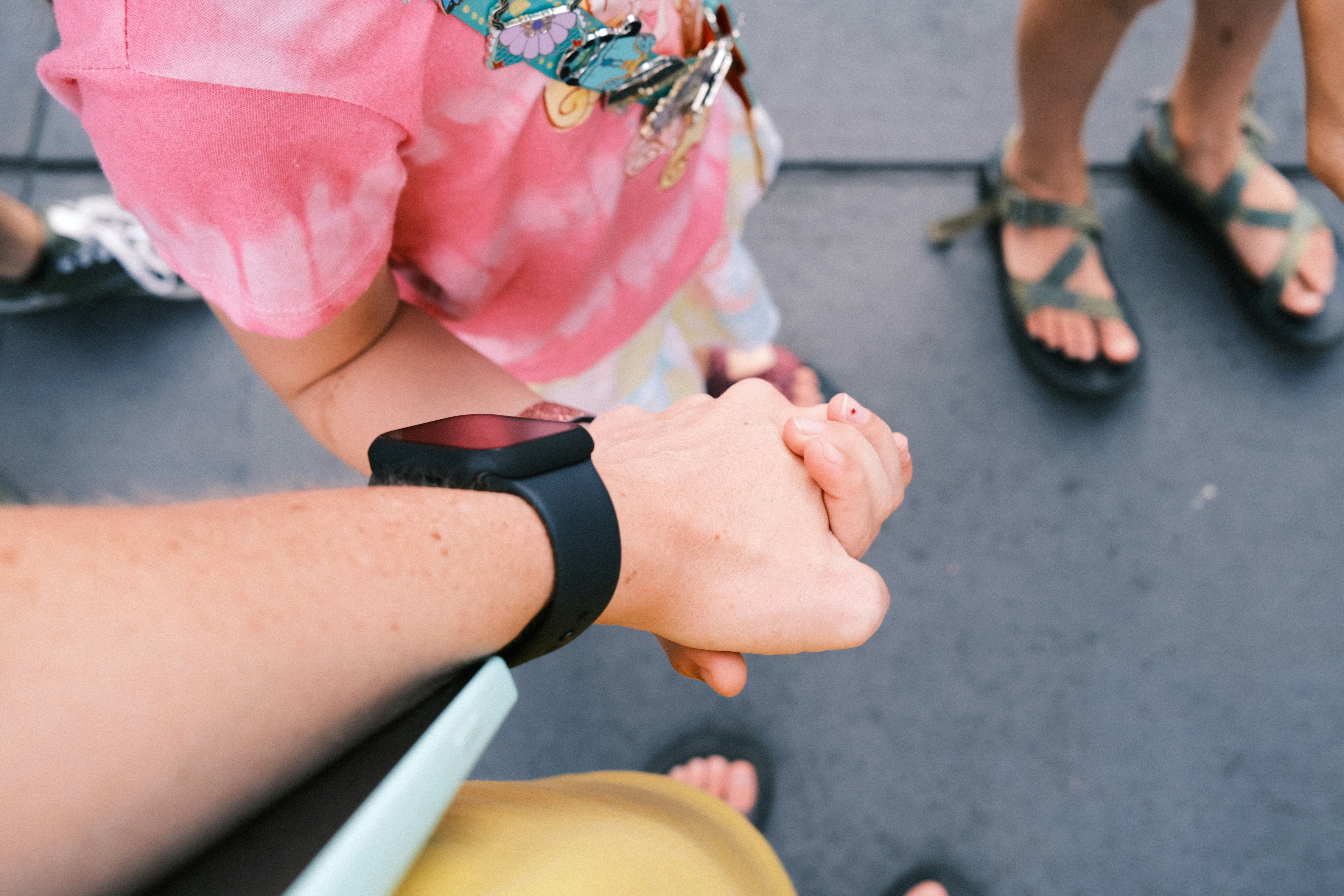 person wearing black watch holding pink and white textile