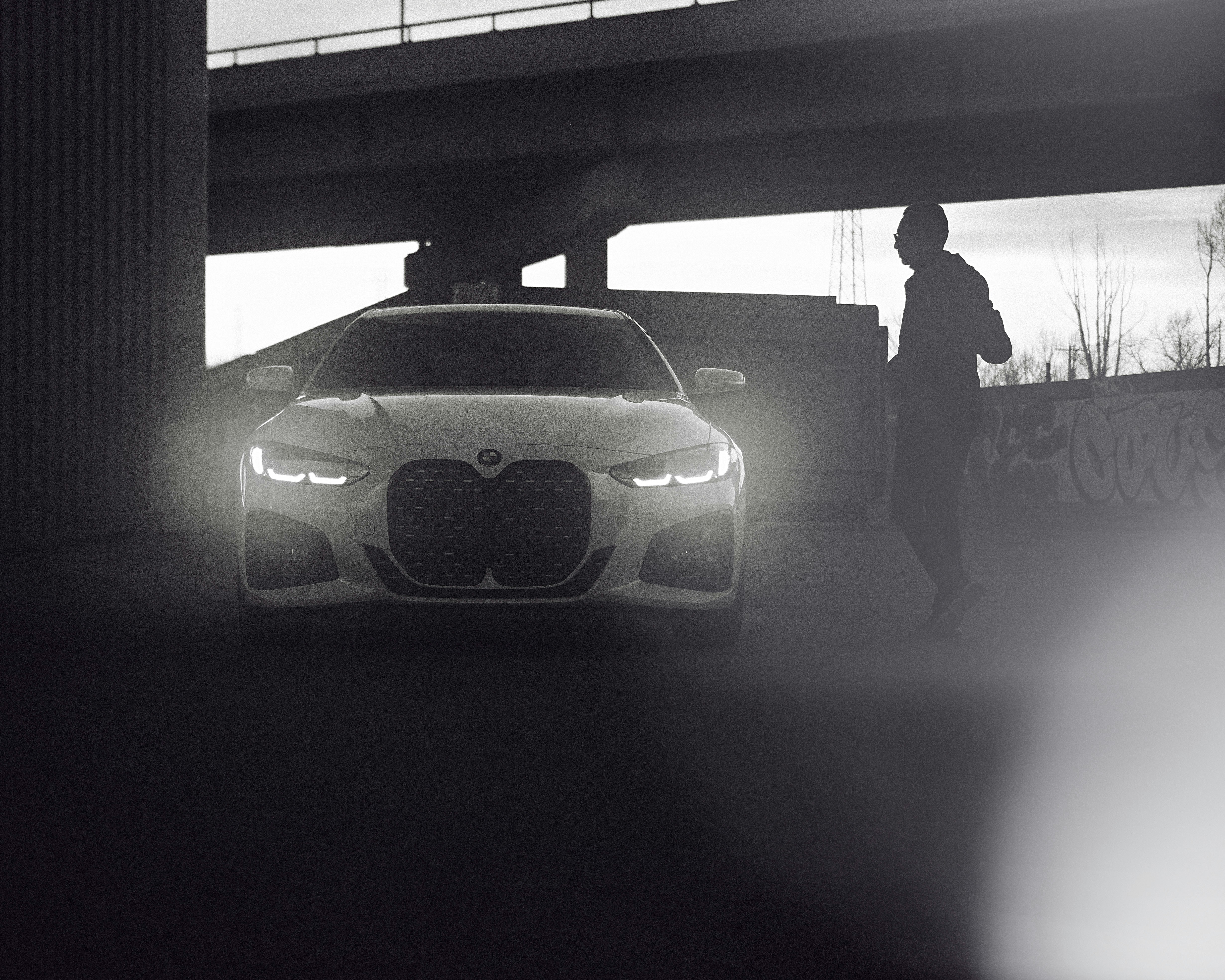 Grayscale photo of man standing beside car photo – Free Bmw Image on ...