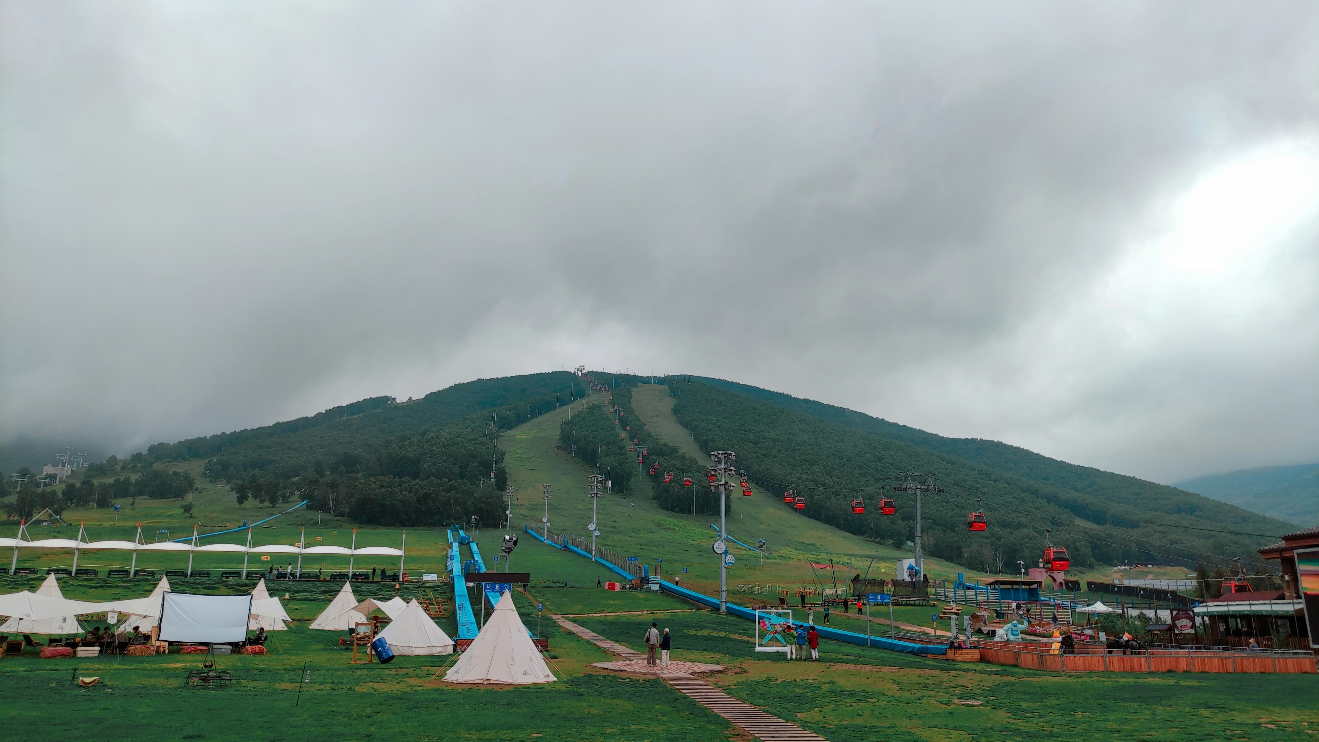 people on green grass field near mountain during daytime