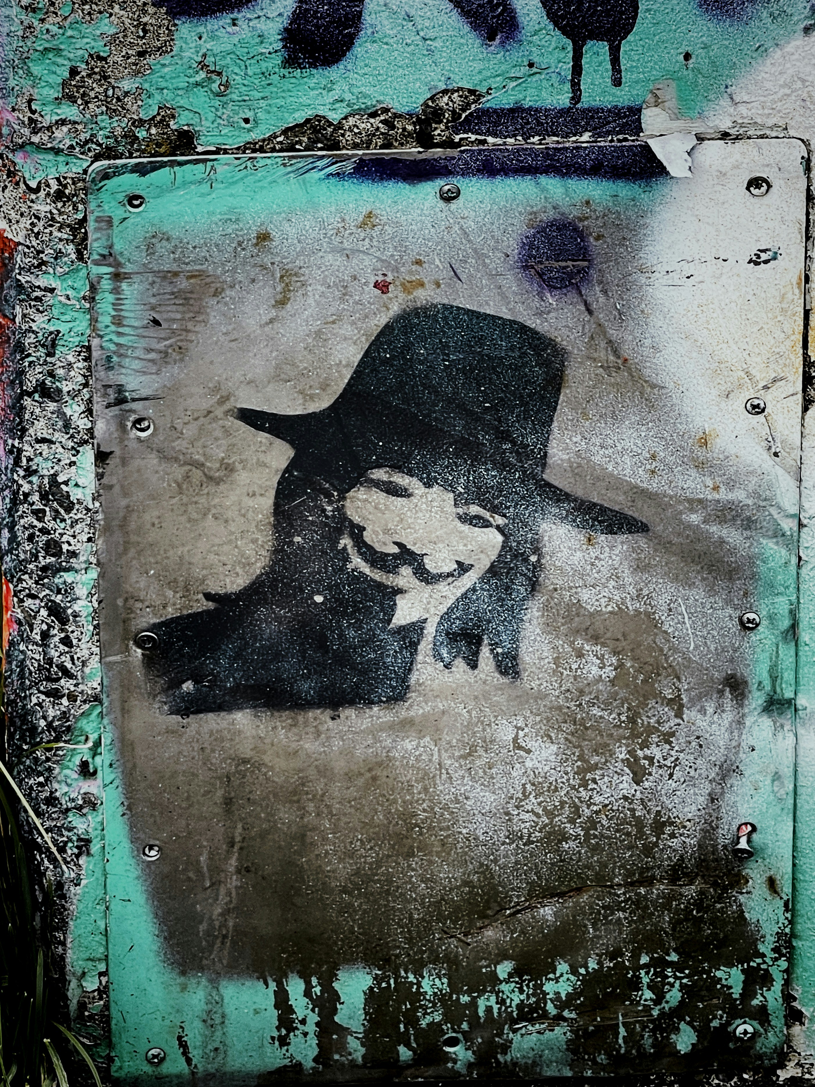 Shadowed Fedora: Street Art Portrait on Weathered Metal