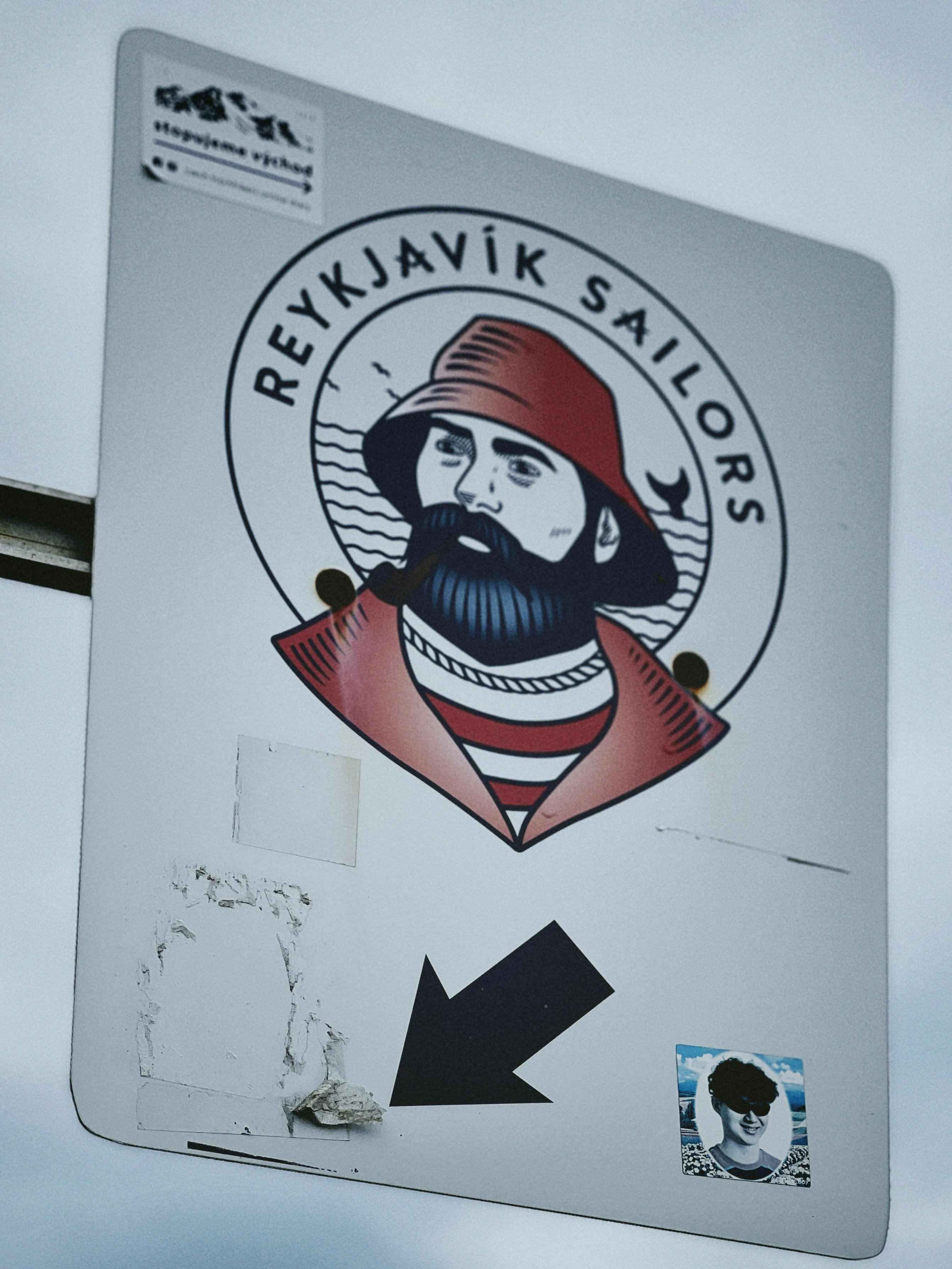 Tilted Reykjavik Sailors Emblem: Bearded Navigator on a Weathered Sign