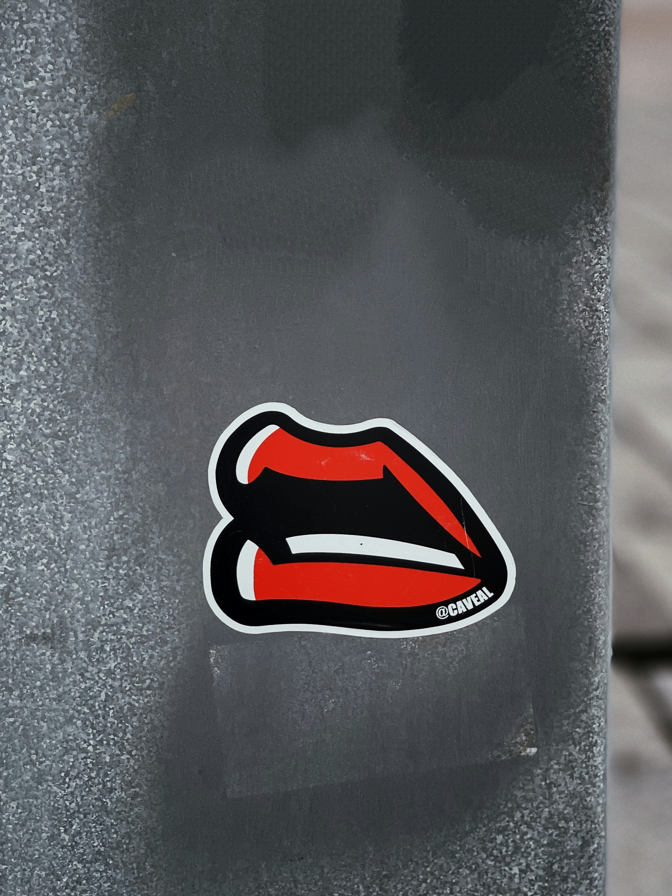Crimson Lip Sticker on Weathered Steel