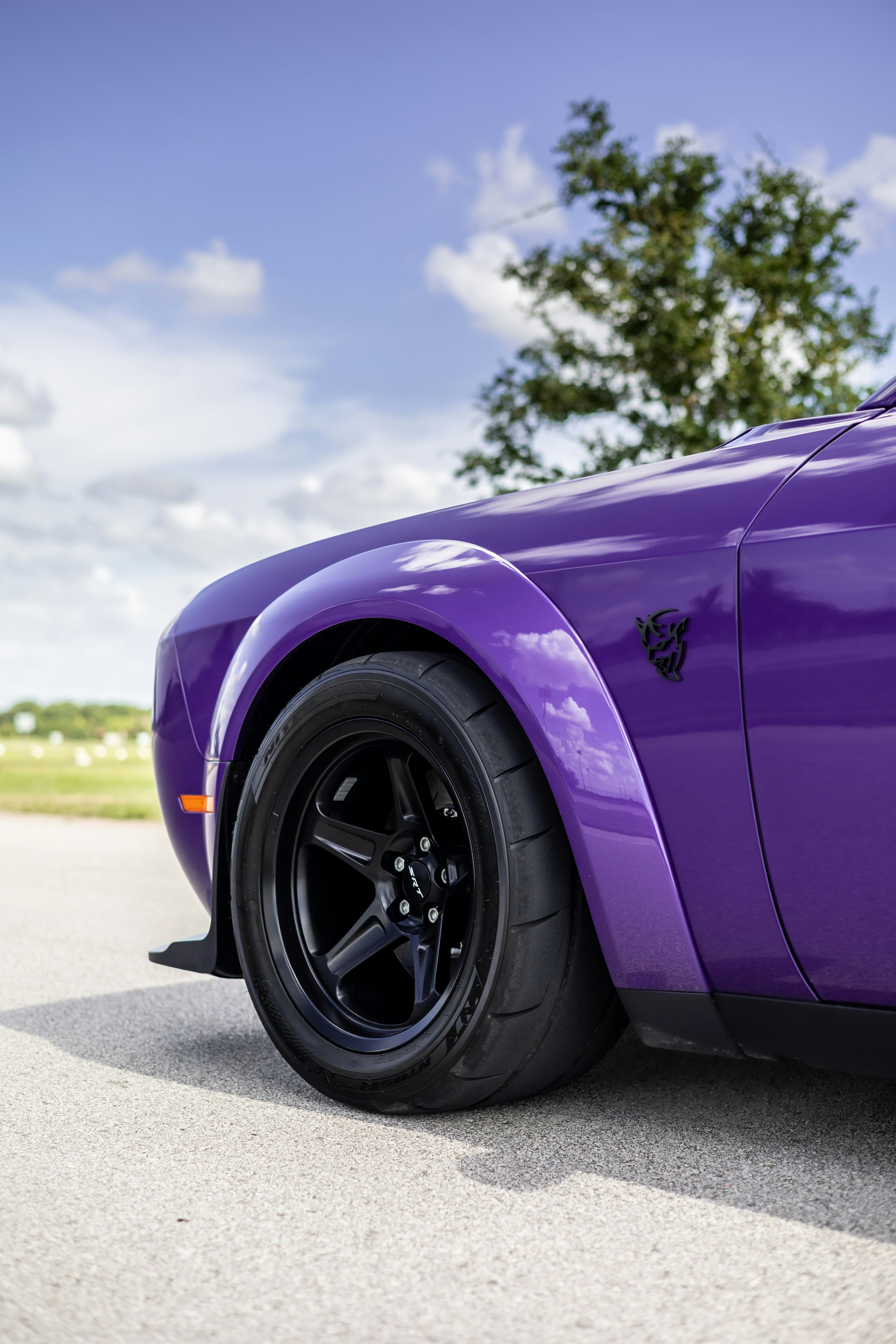 Lavender Torque: Close-Up of a Purple Muscle Car Wheel in Sunlit Detail